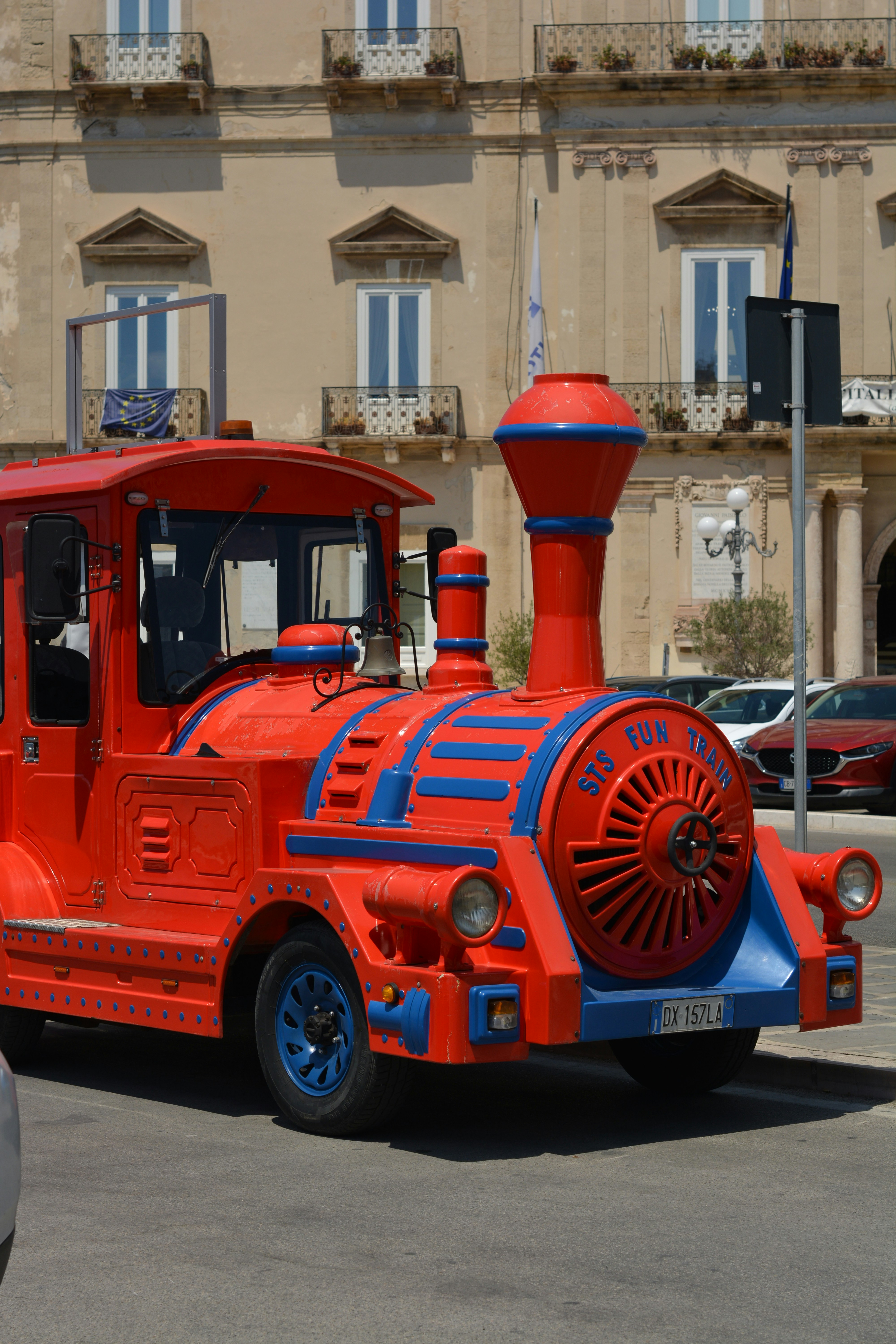 Bright Red Locomotive on a Sunlit City Street
