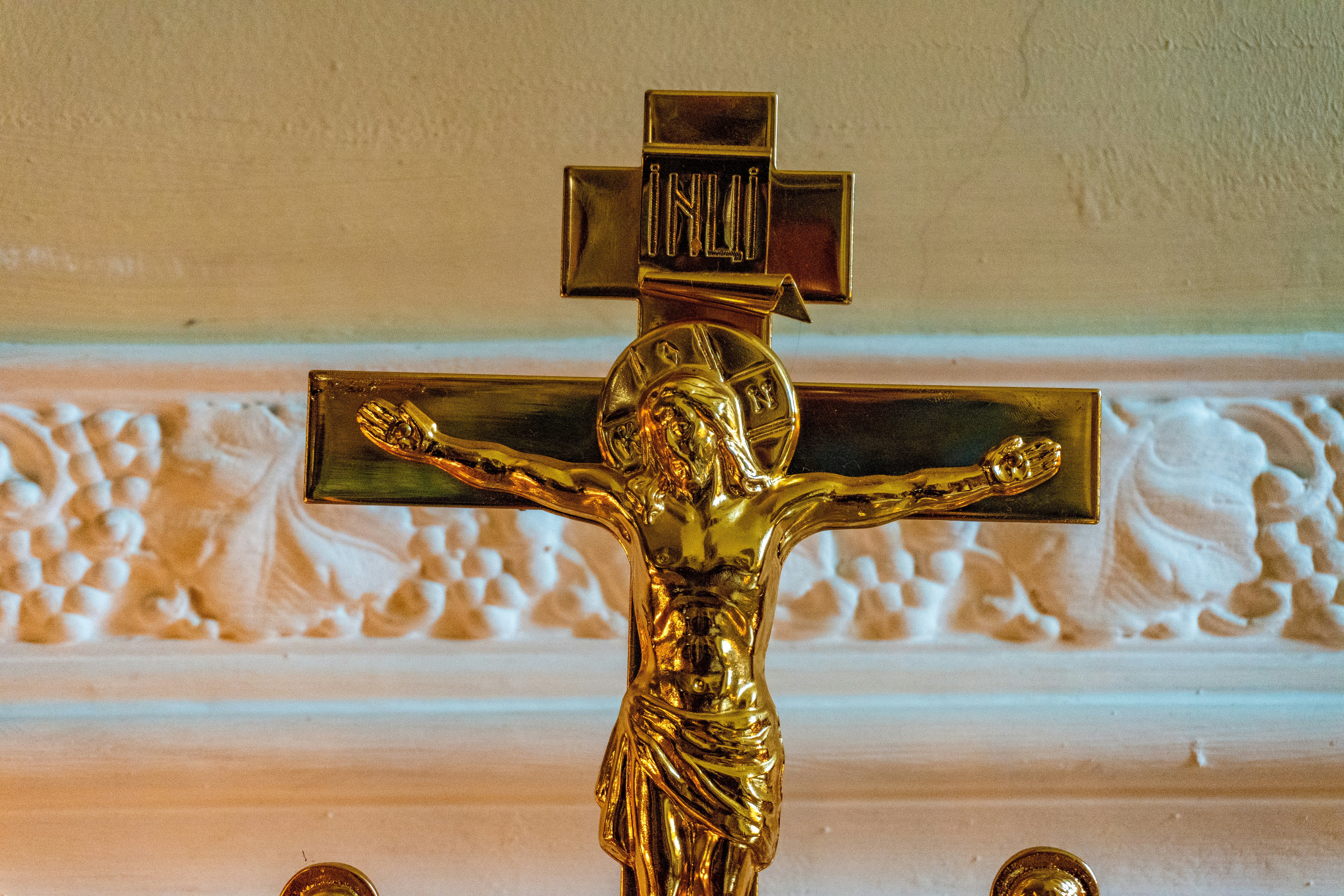 Golden crucifix centerpiece: a close-up of a gilded statue framing a cross