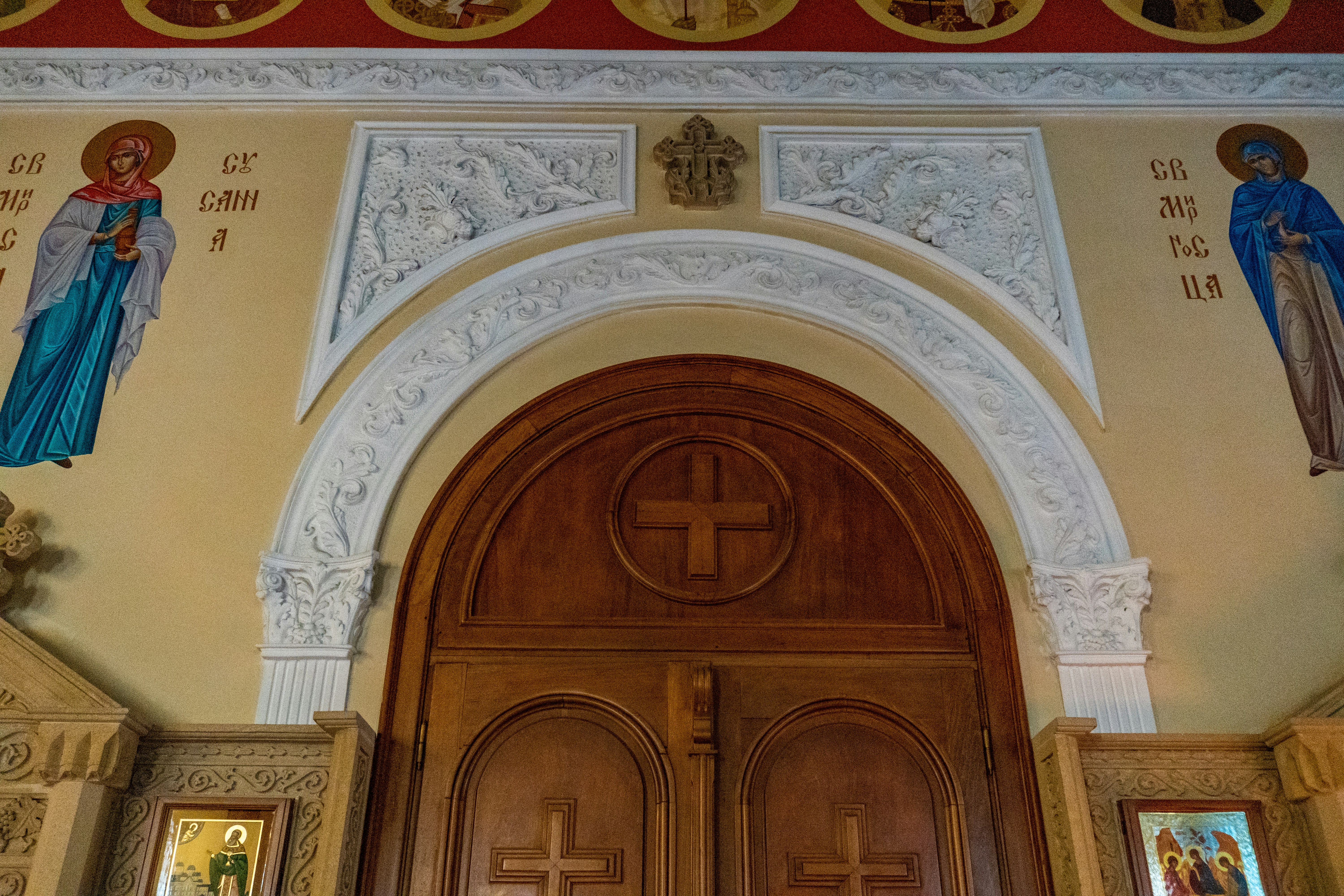 Arched church doorway framed by ornate plasterwork and icons