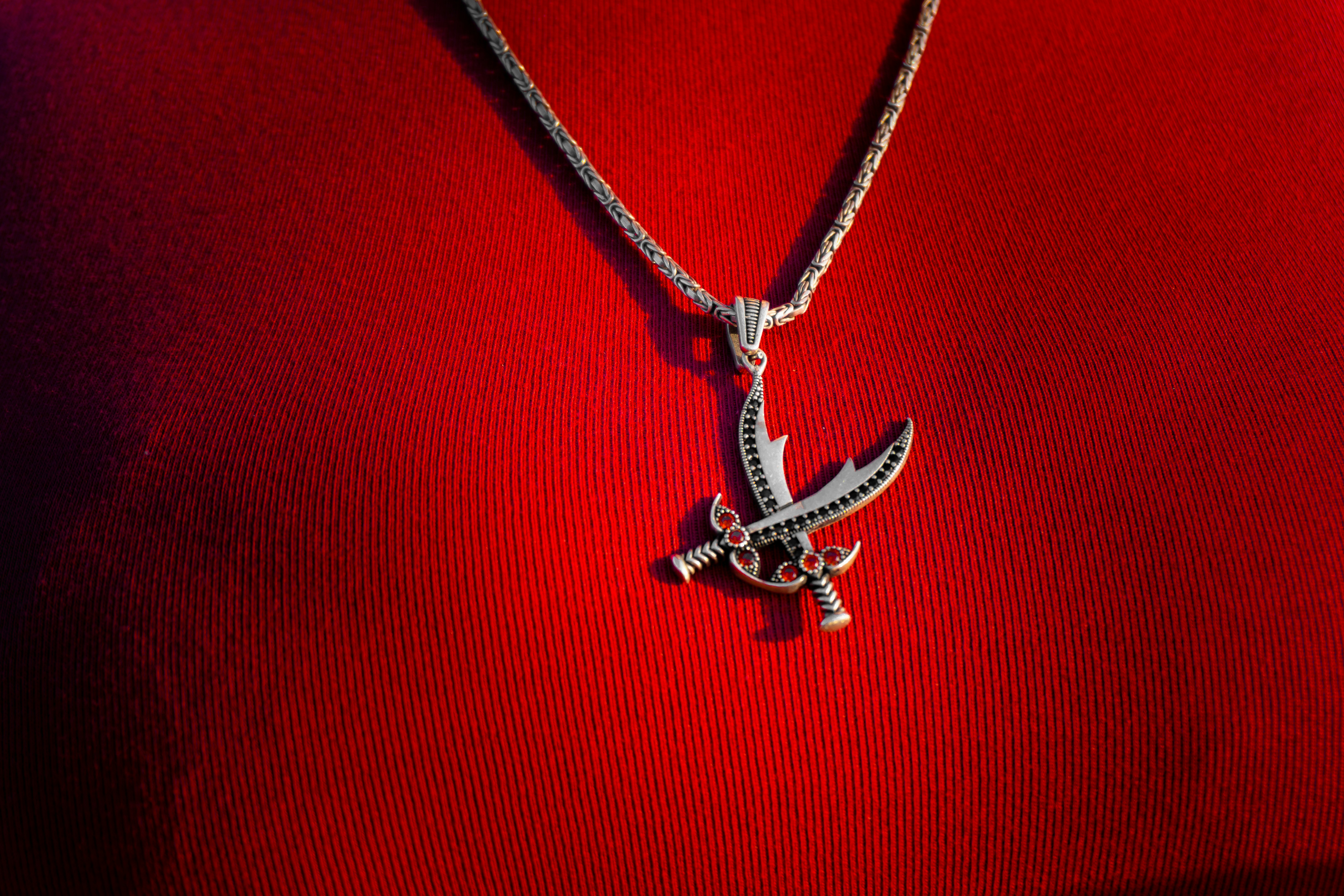 Crimson Pendant: A Silver Crescent Necklace Resting on Velvet Red