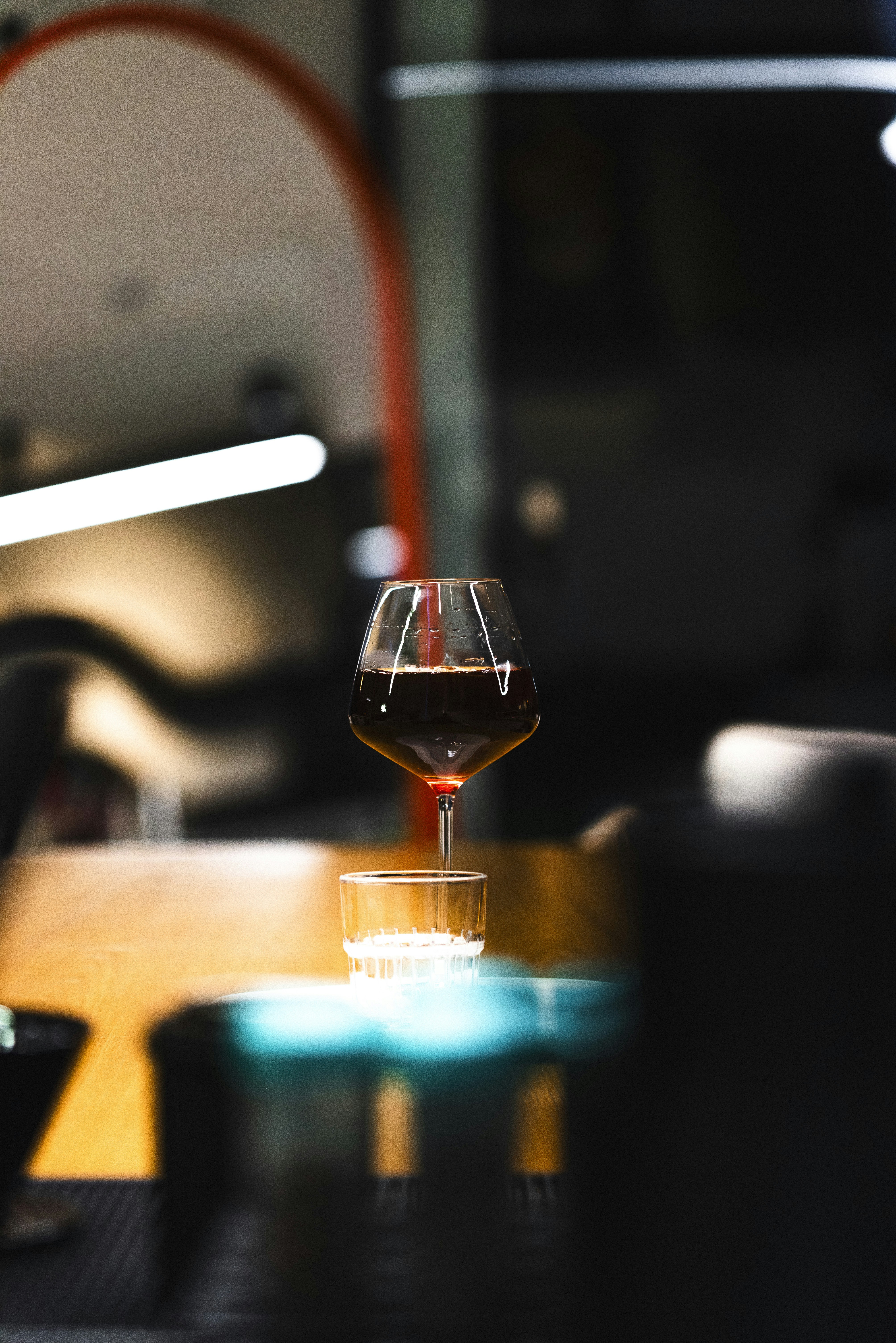 Wine Glass Reverie: A Dim Bar Spotlight on a Ruby Elixir