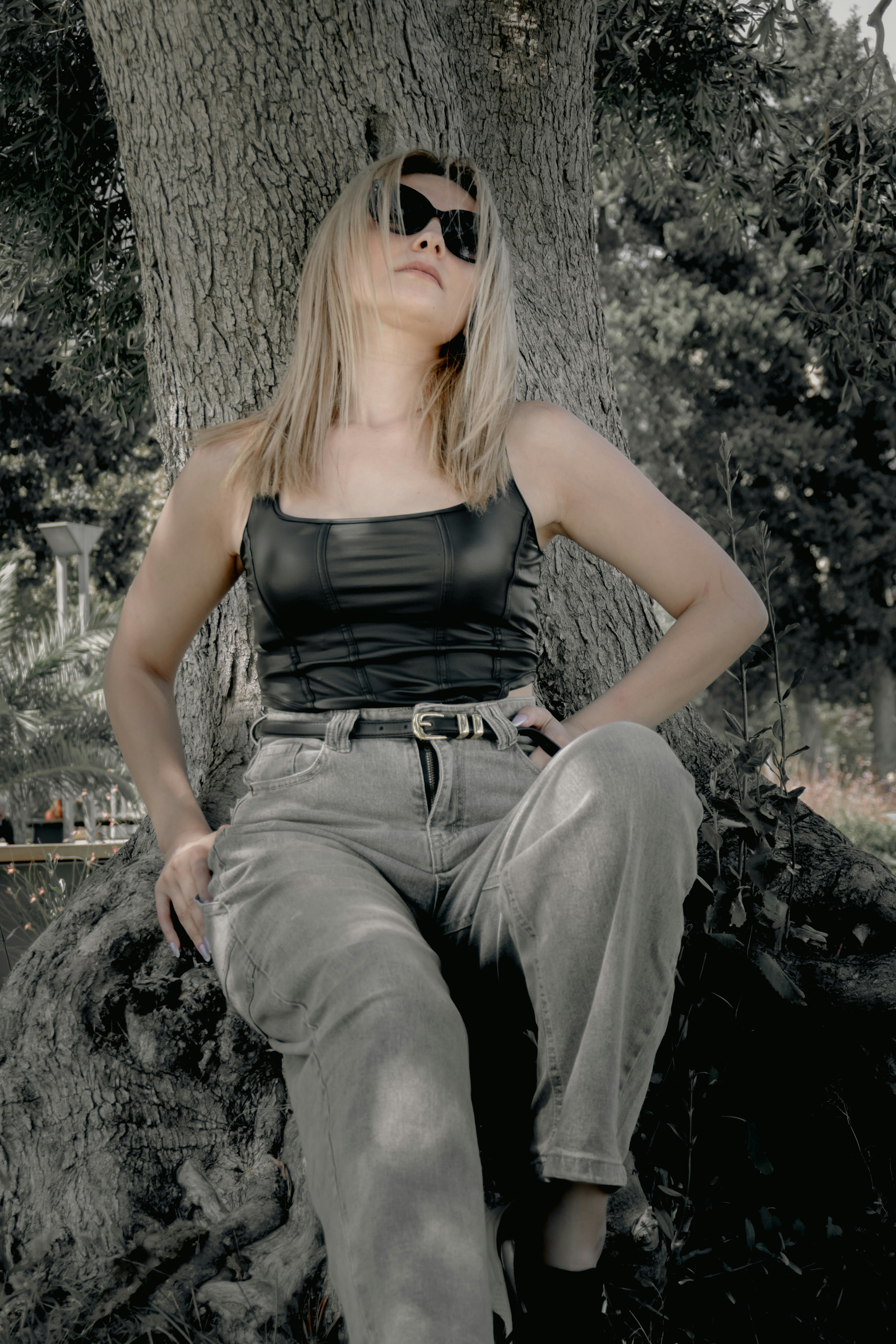 Sunglassed Confidence: Chairbound Pose under a Trunked Shade