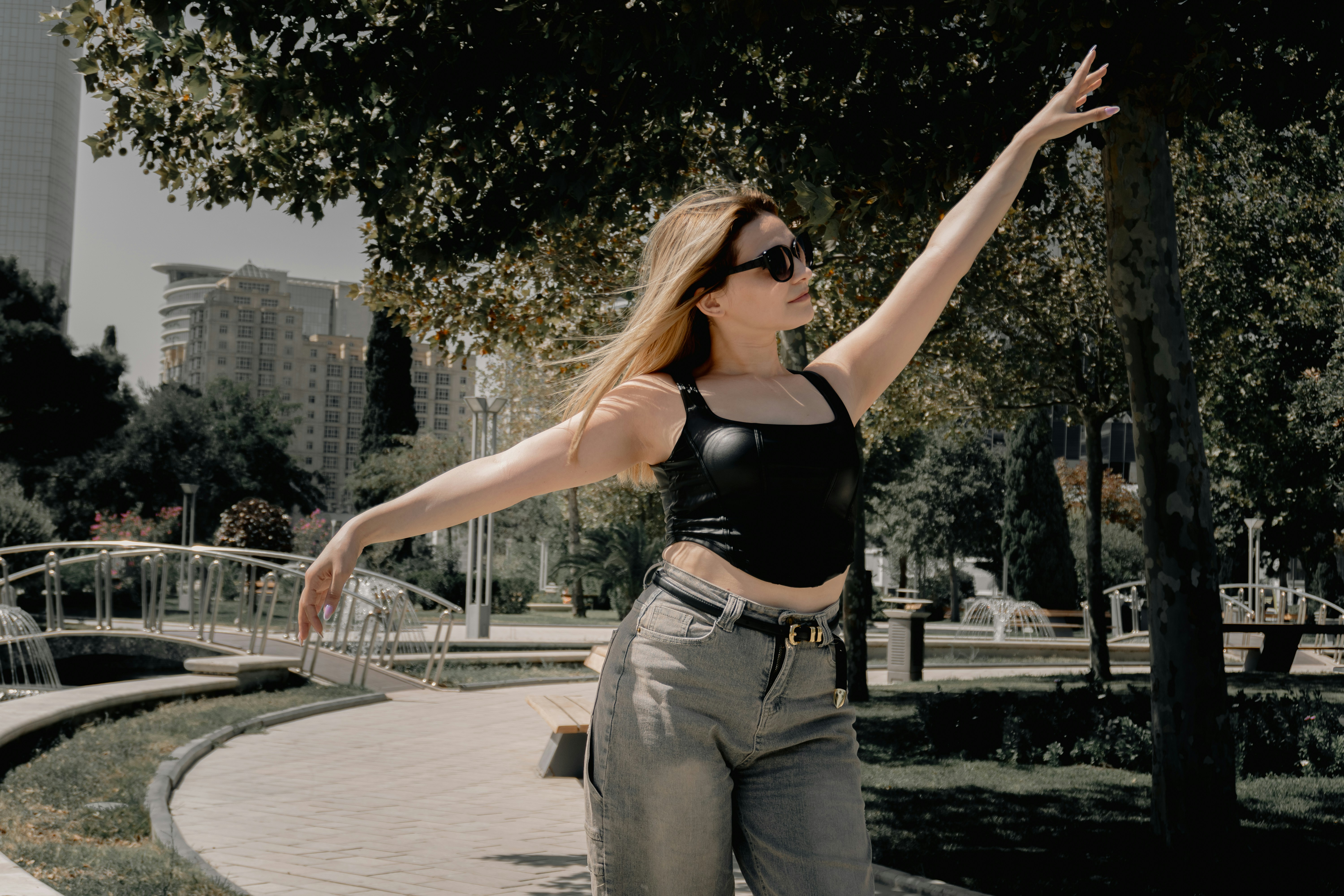 Expressive Dance Pose Against Urban Park Backdrop