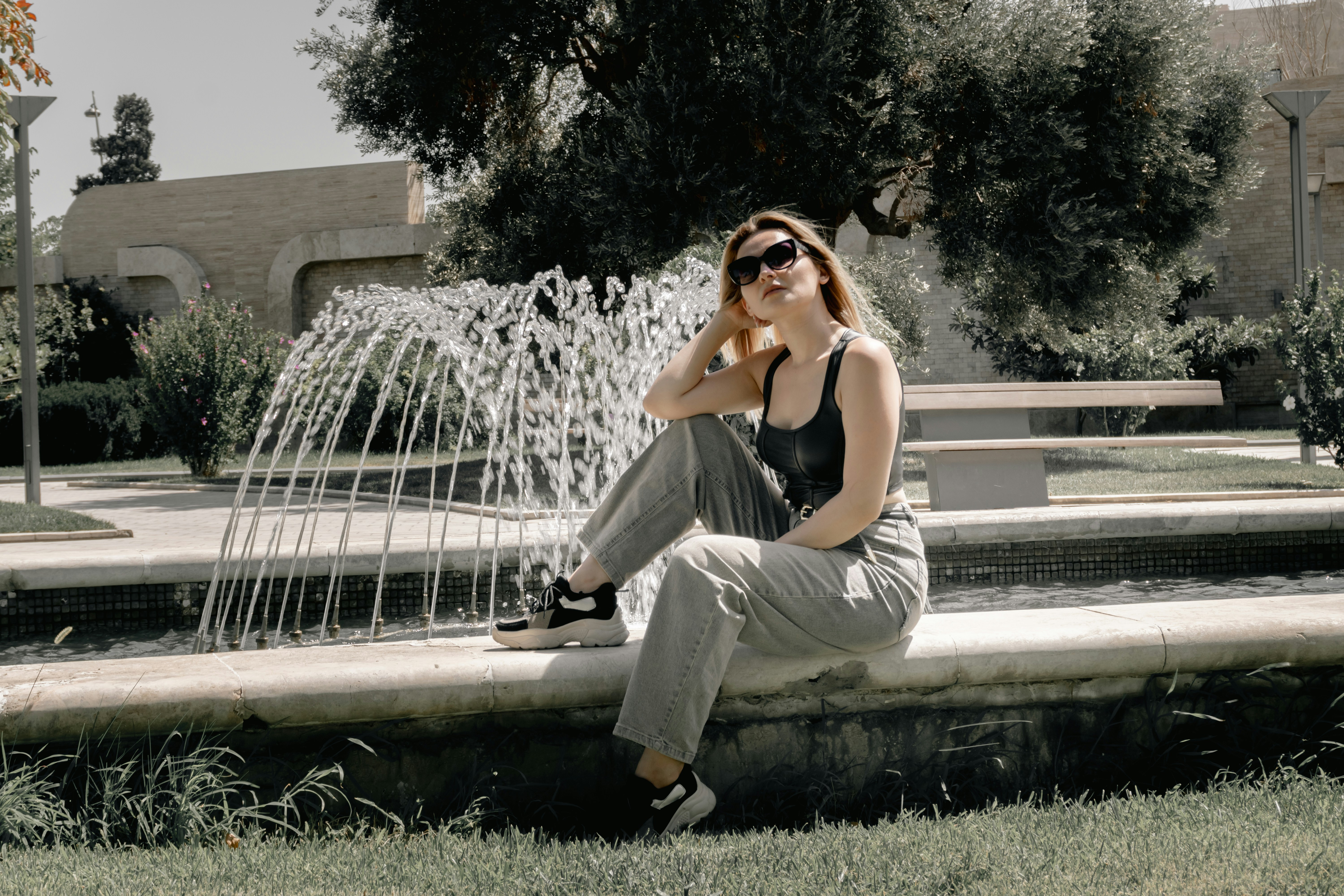 Woman by a Sunlit Fountain: Contemplative Cool in the Courtyard