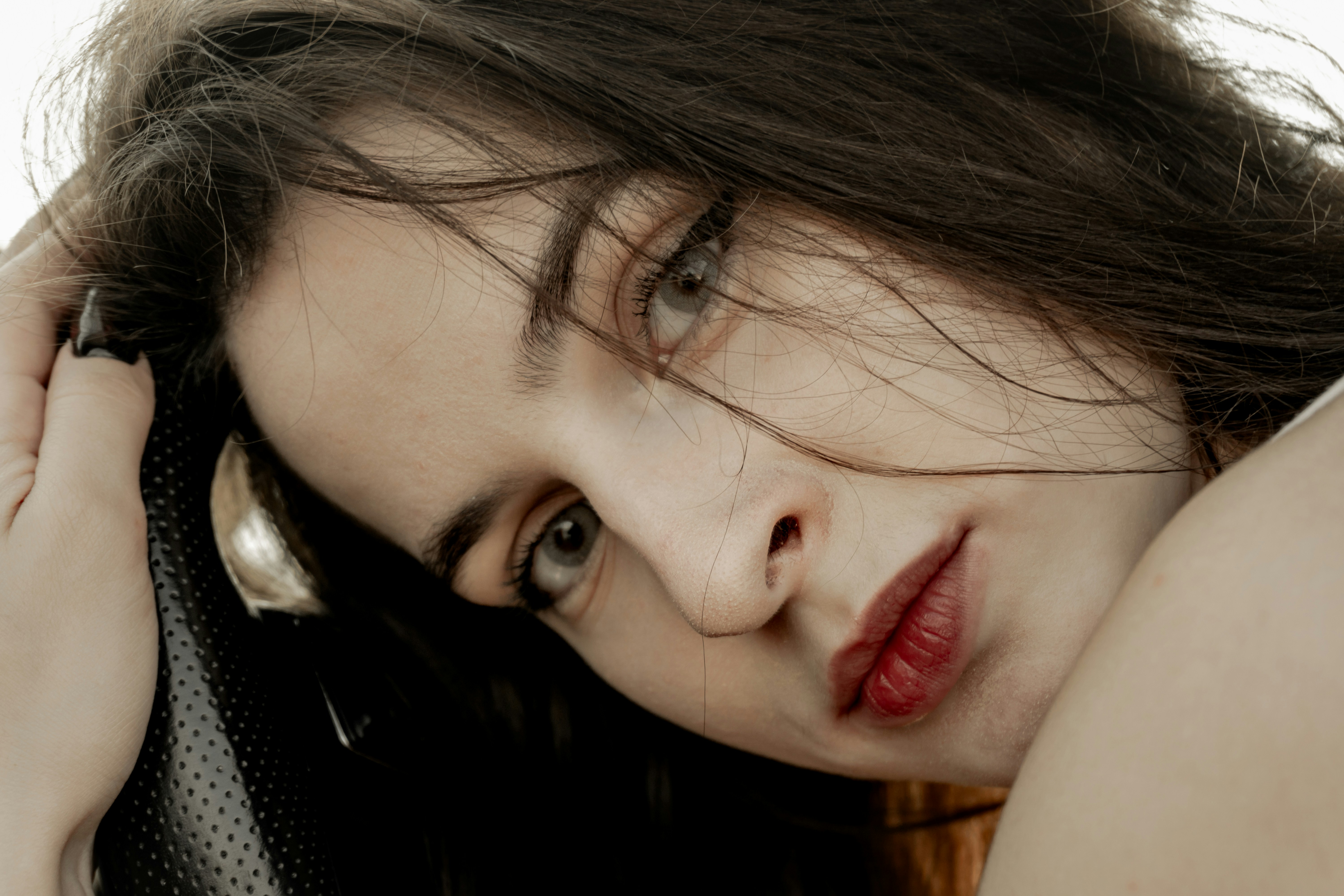 Close-up of a contemplative gaze: red lips and tousled hair