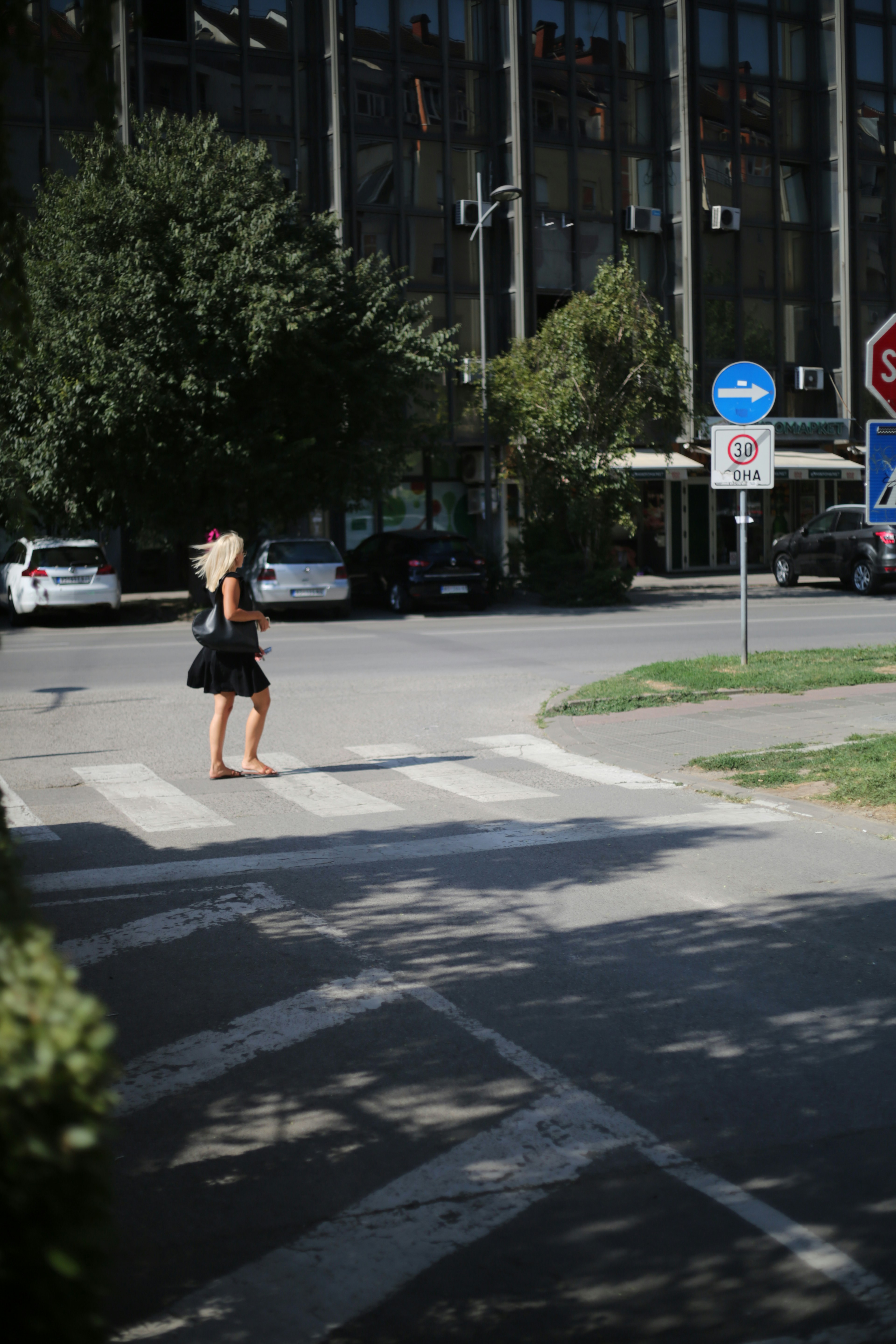 Crosswalk Moment: A Woman in Black Steps into the Light