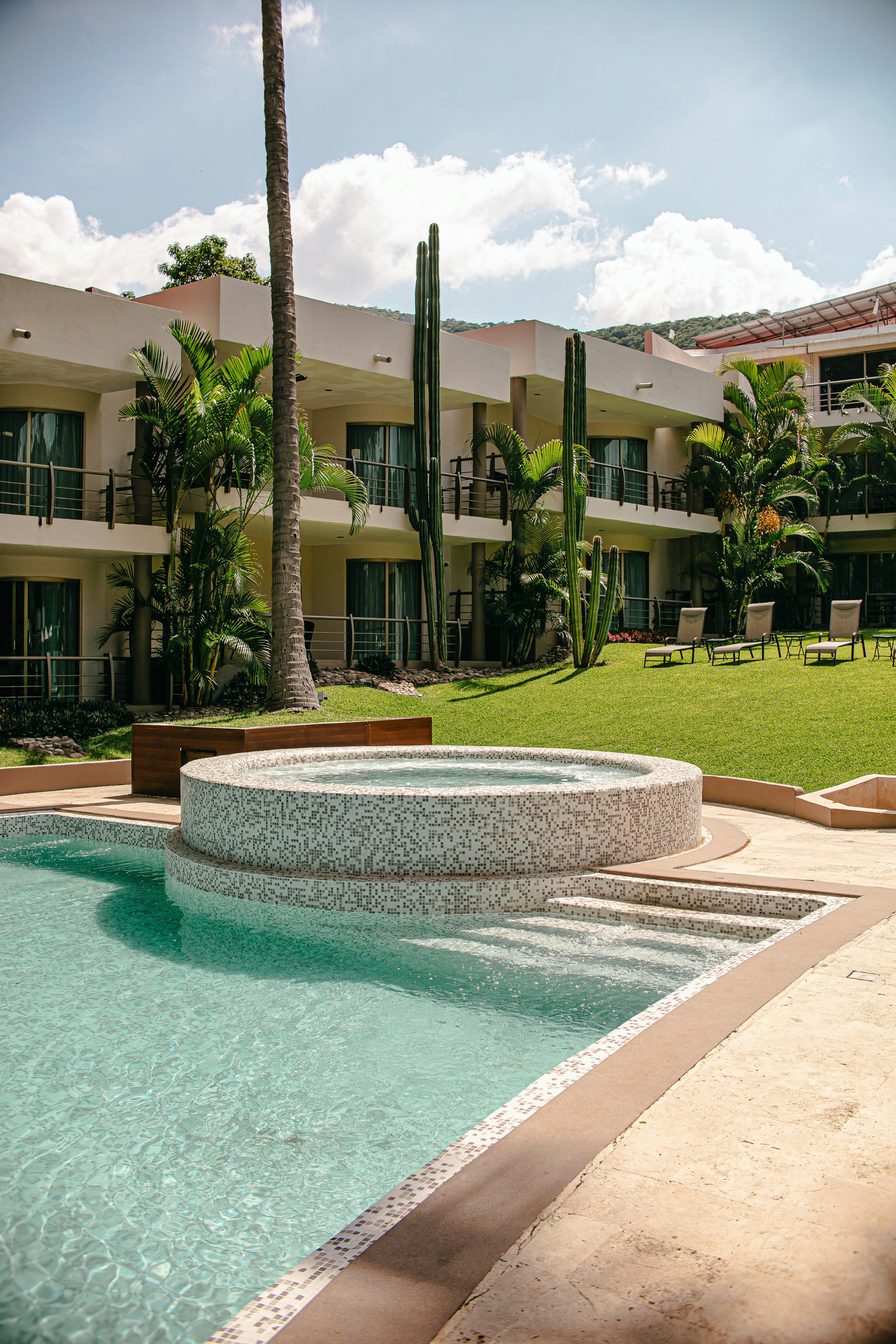 Circular fountain centerpiece framed by terrace hotel and lush palms
