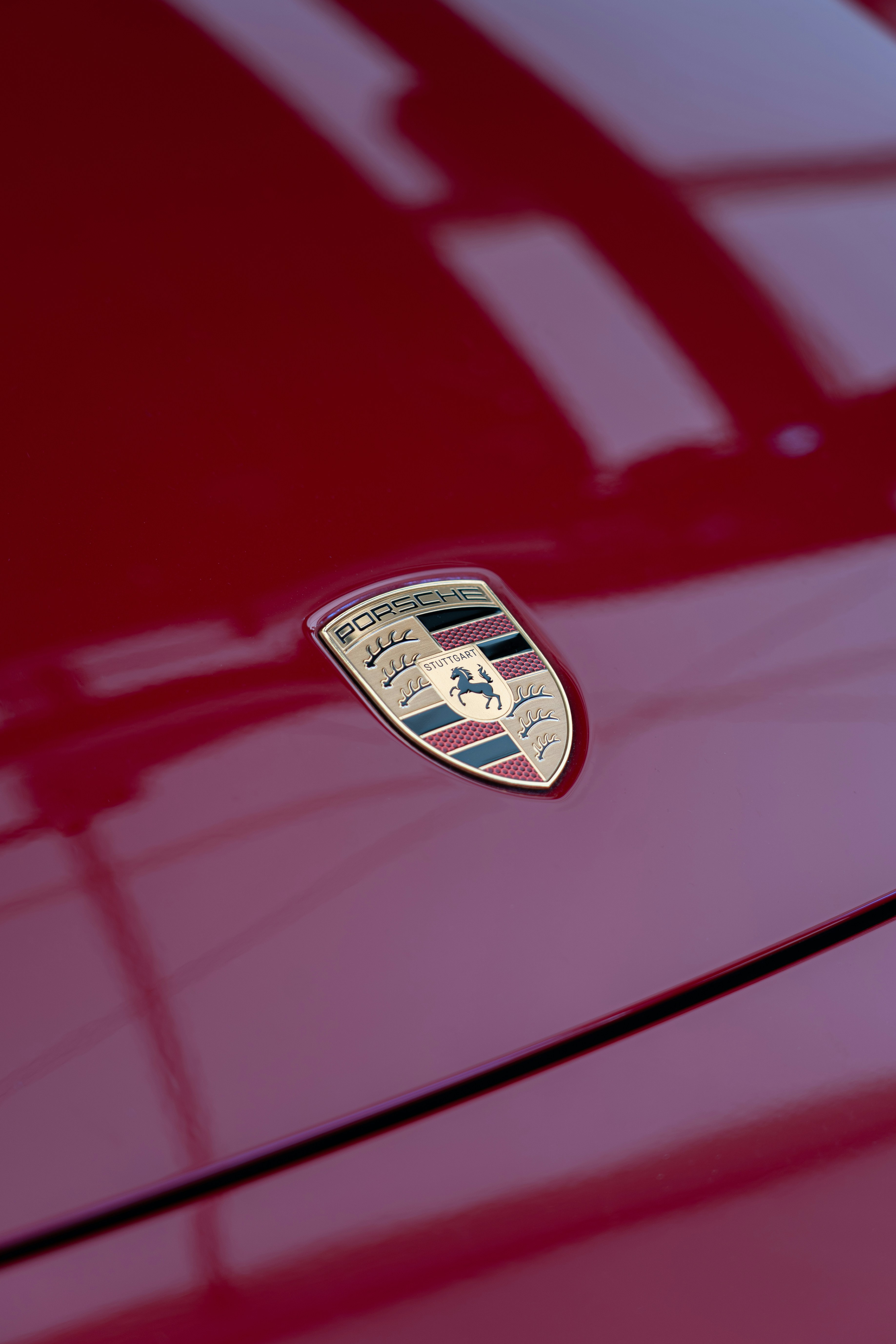 Emblem of Motion: Porsche Crest on a Crimson Surface