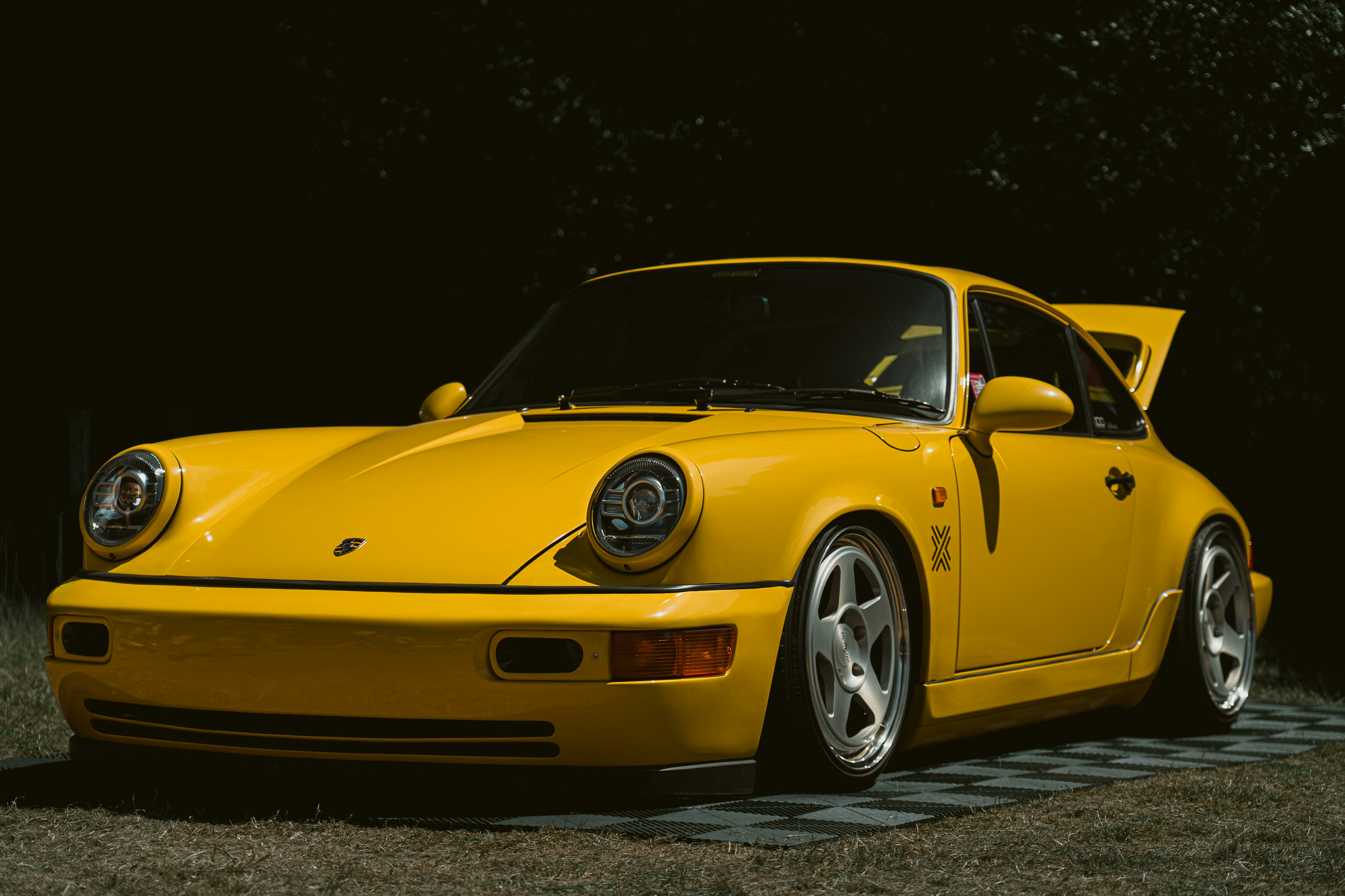 Sunlit Yellow Porsche: The Low Stance on a Checkered Path