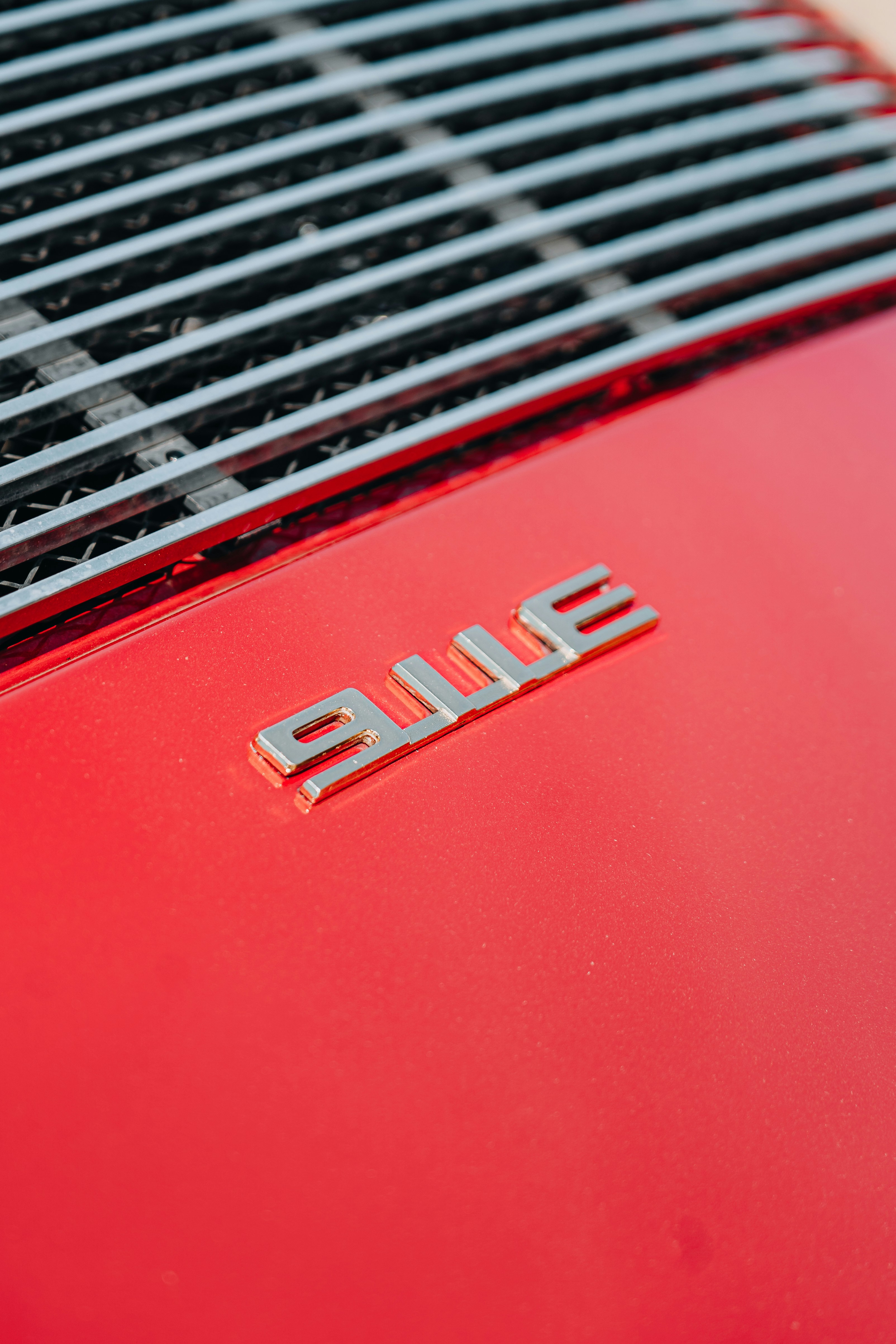 Scarlet Engine: The Corvette Badge on Red Grille