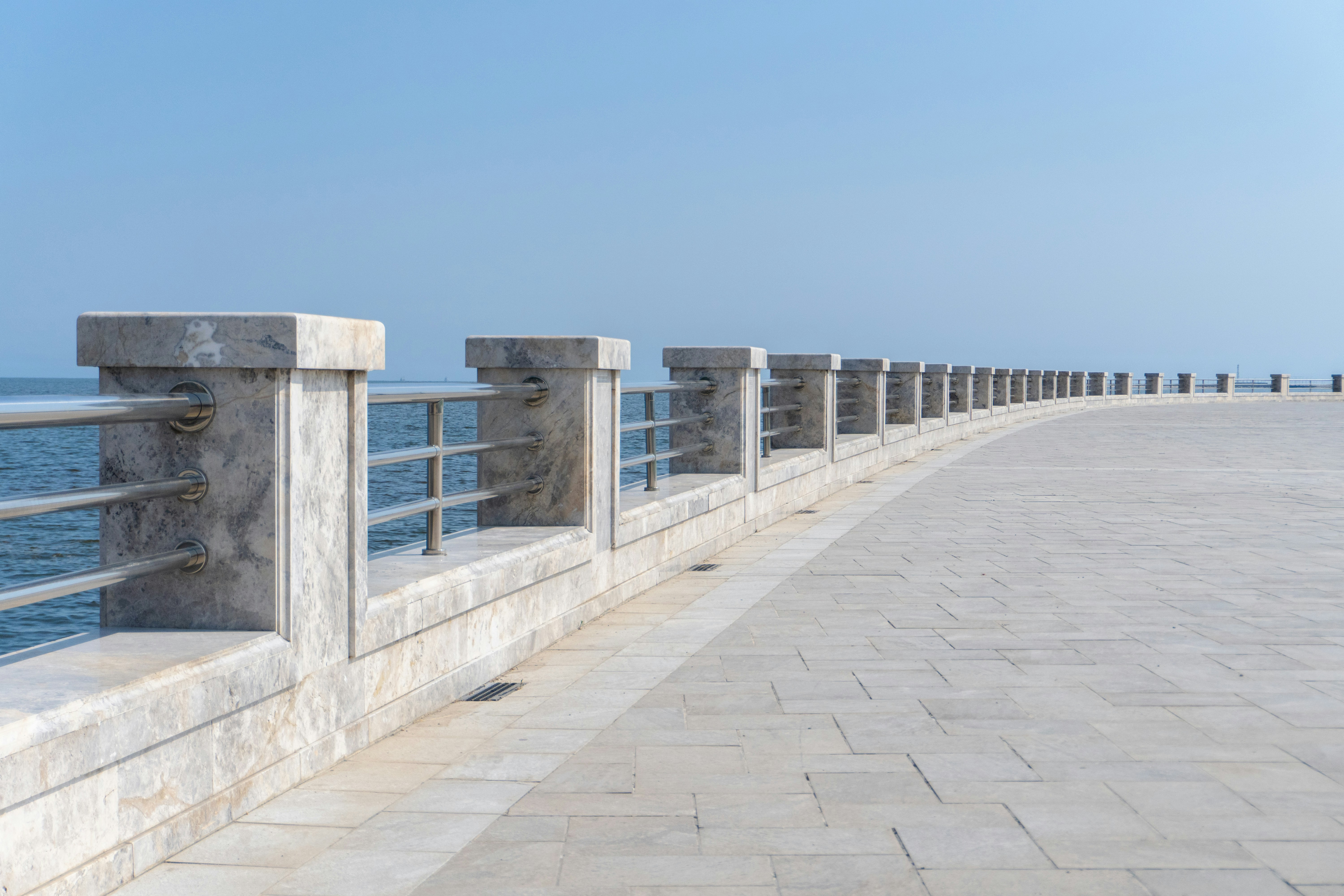 Endless Pier: Stone Railings Recede Toward a Calm Sea