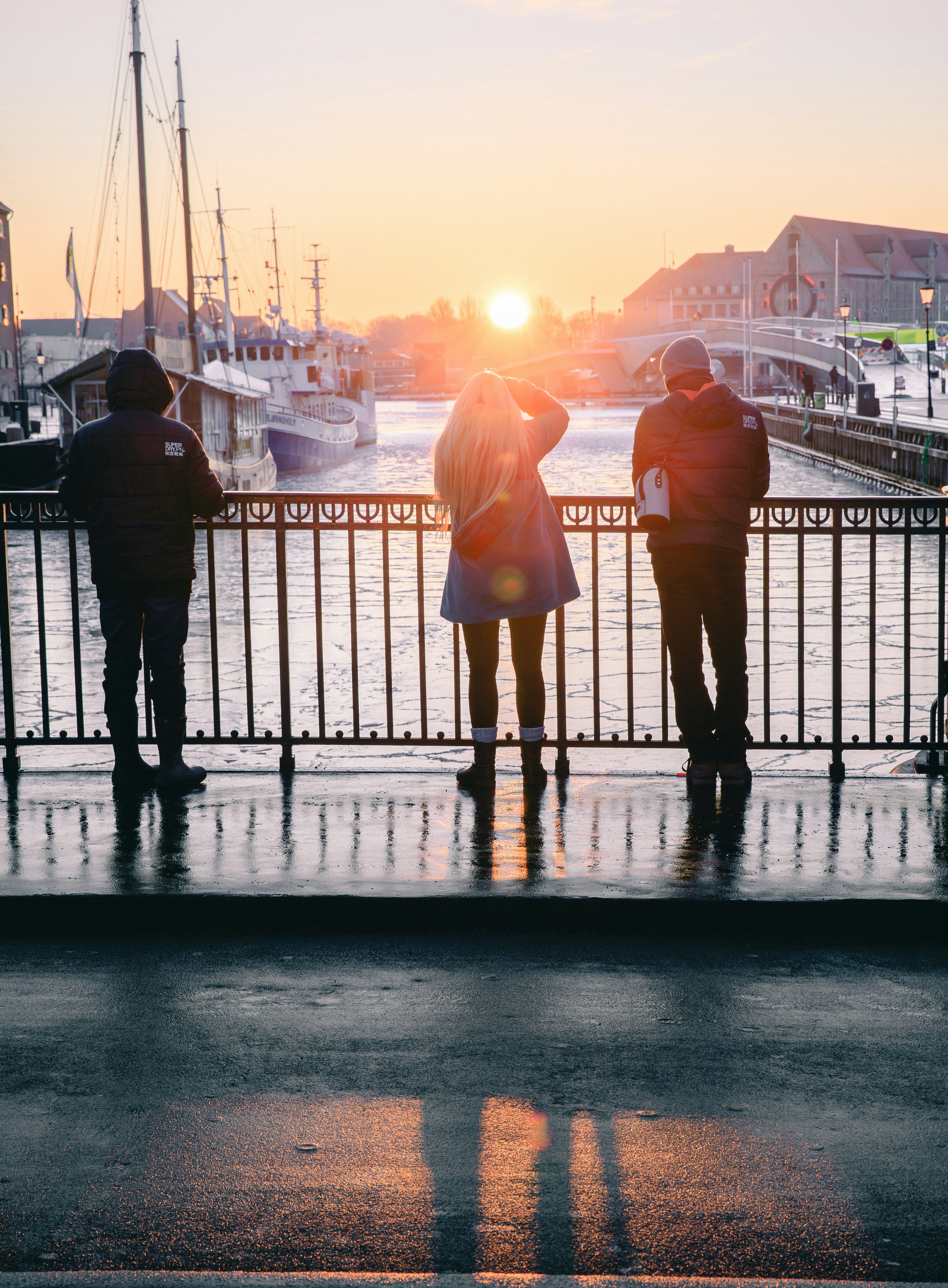 Sunlit silhouettes at the harbor railing