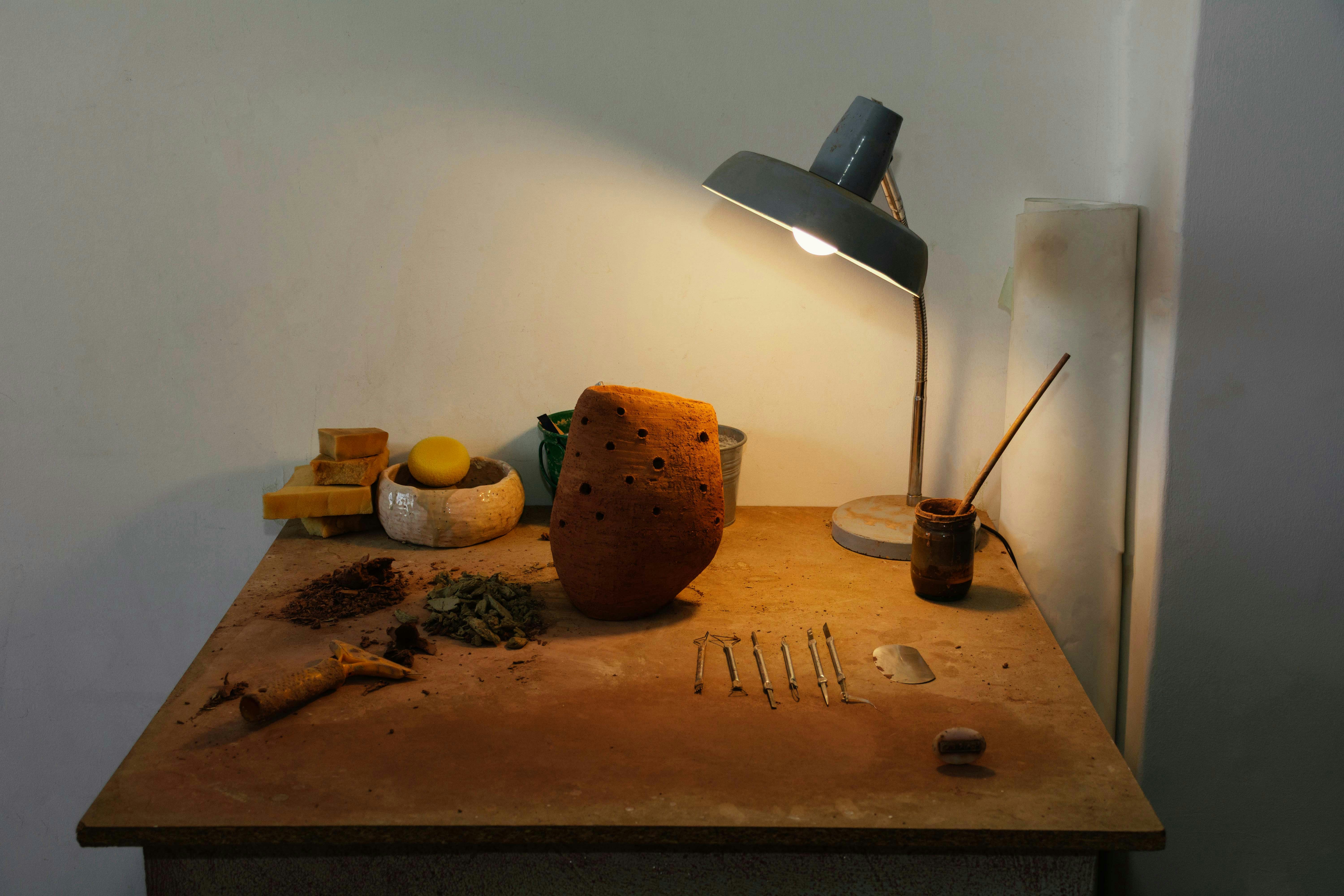 Studio still life: warm cheese, crusty loaf, and lamp-lit workspace