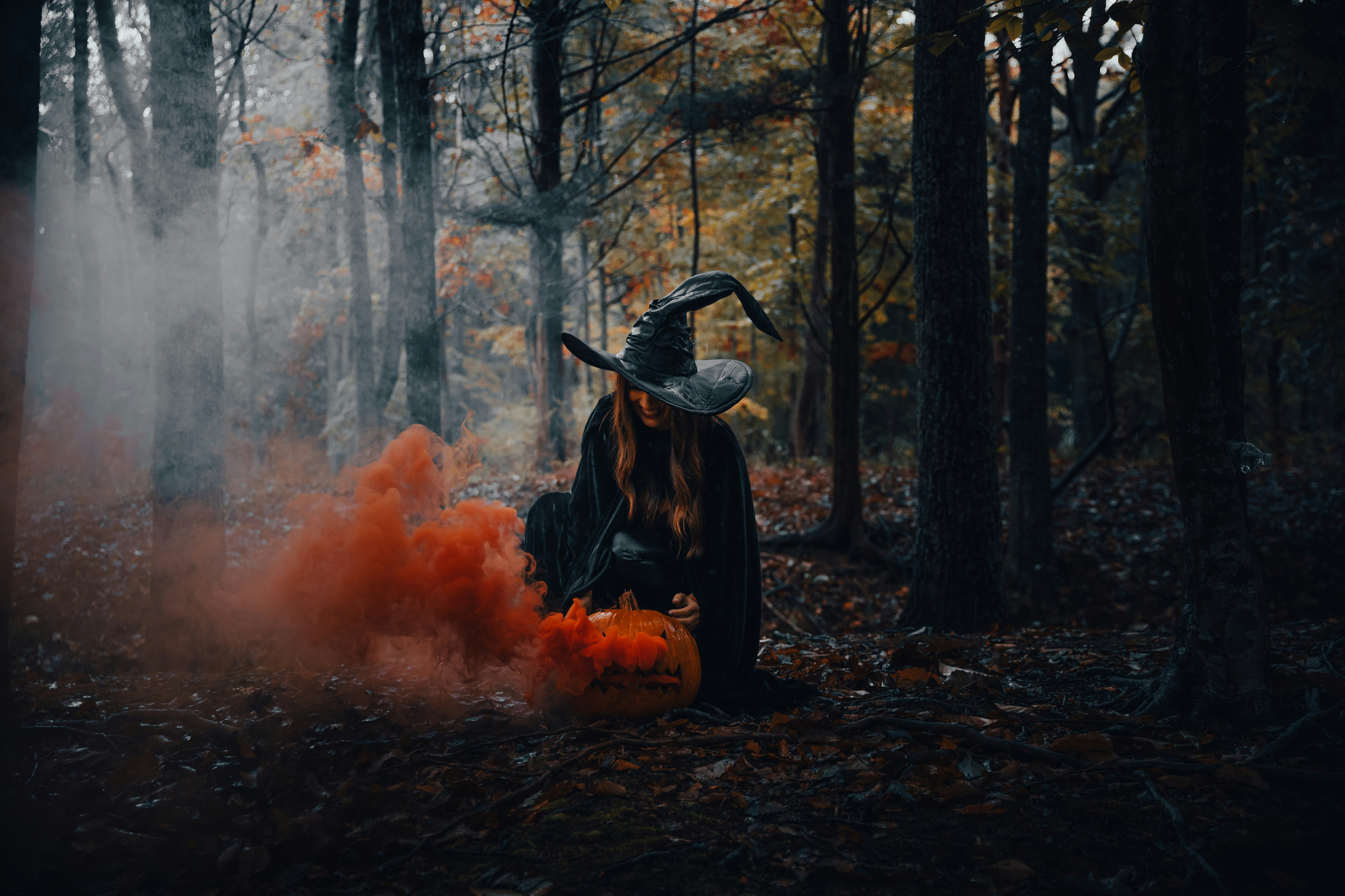 Forest Witch with Smoke and Pumpkin under Dim Canopy