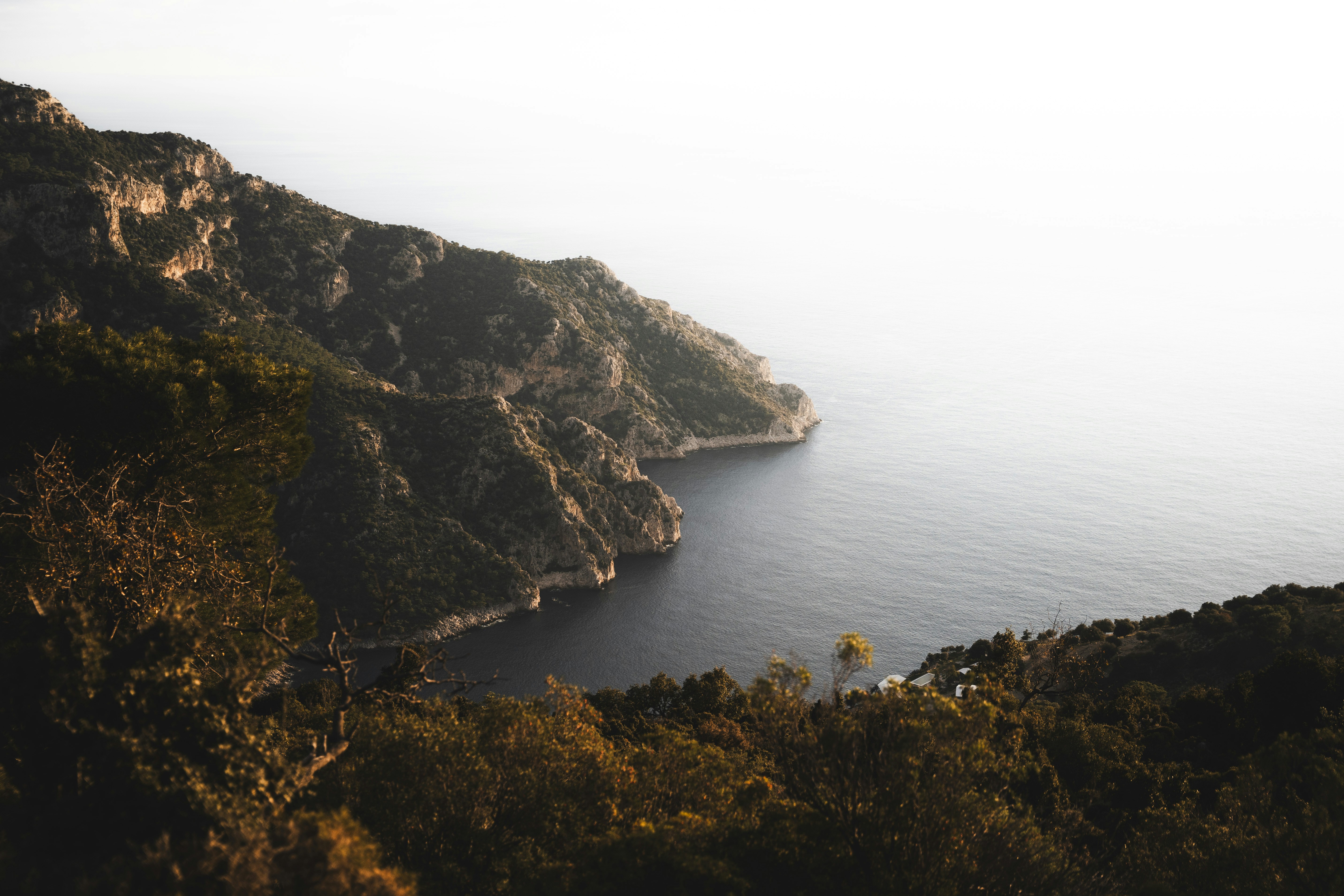 Sunlit Coves: Cliffside Coastline Fade into Mist