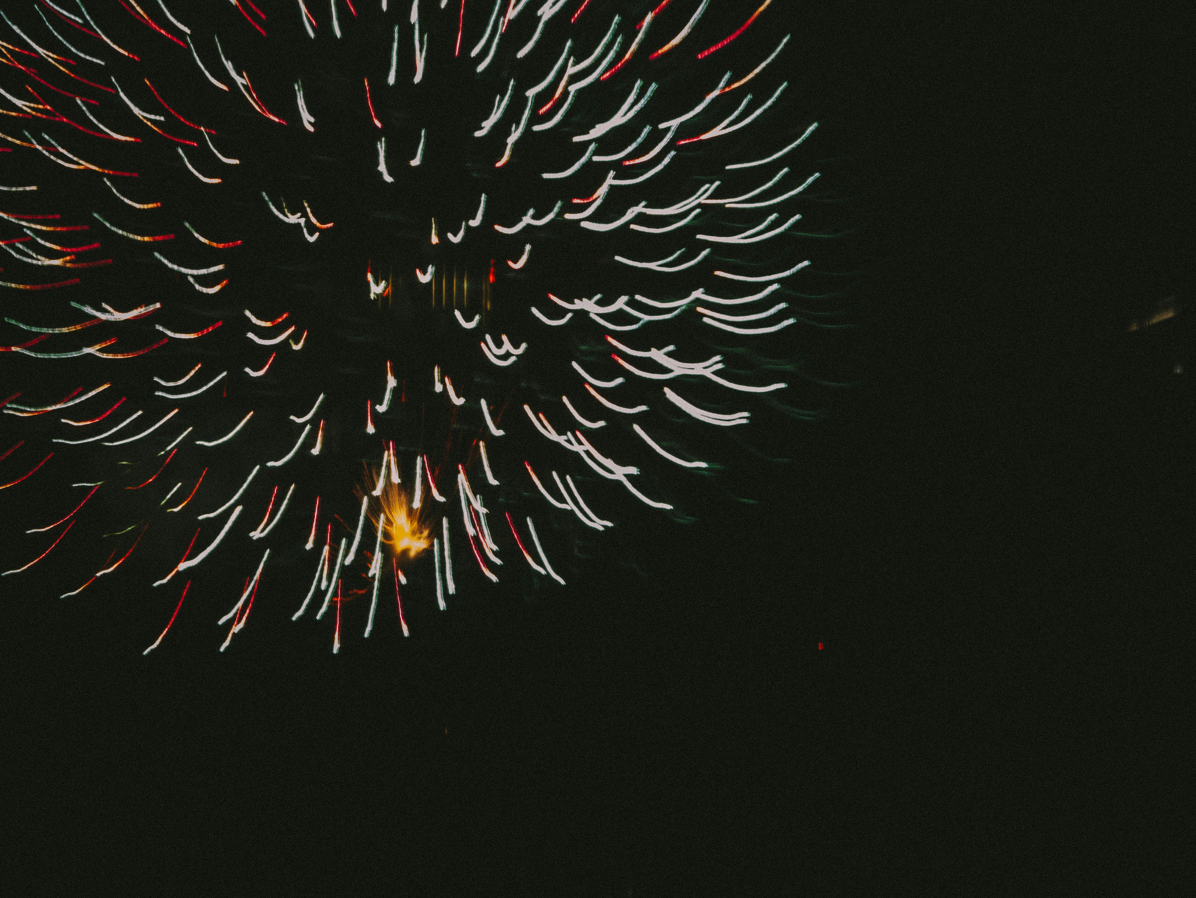 Firework bloom over dark skies: a milky arc of color