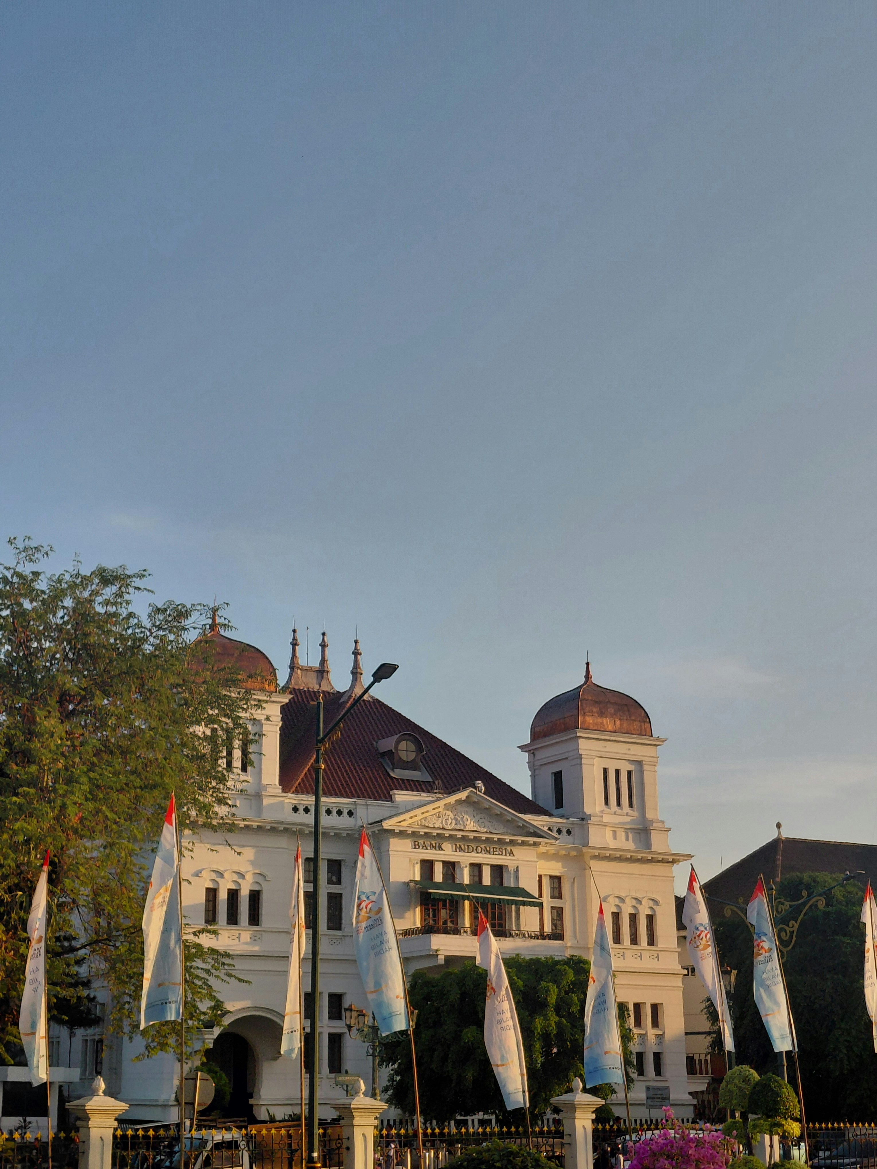 Sunlit Municipal Building with Flags Under a Clear Sky