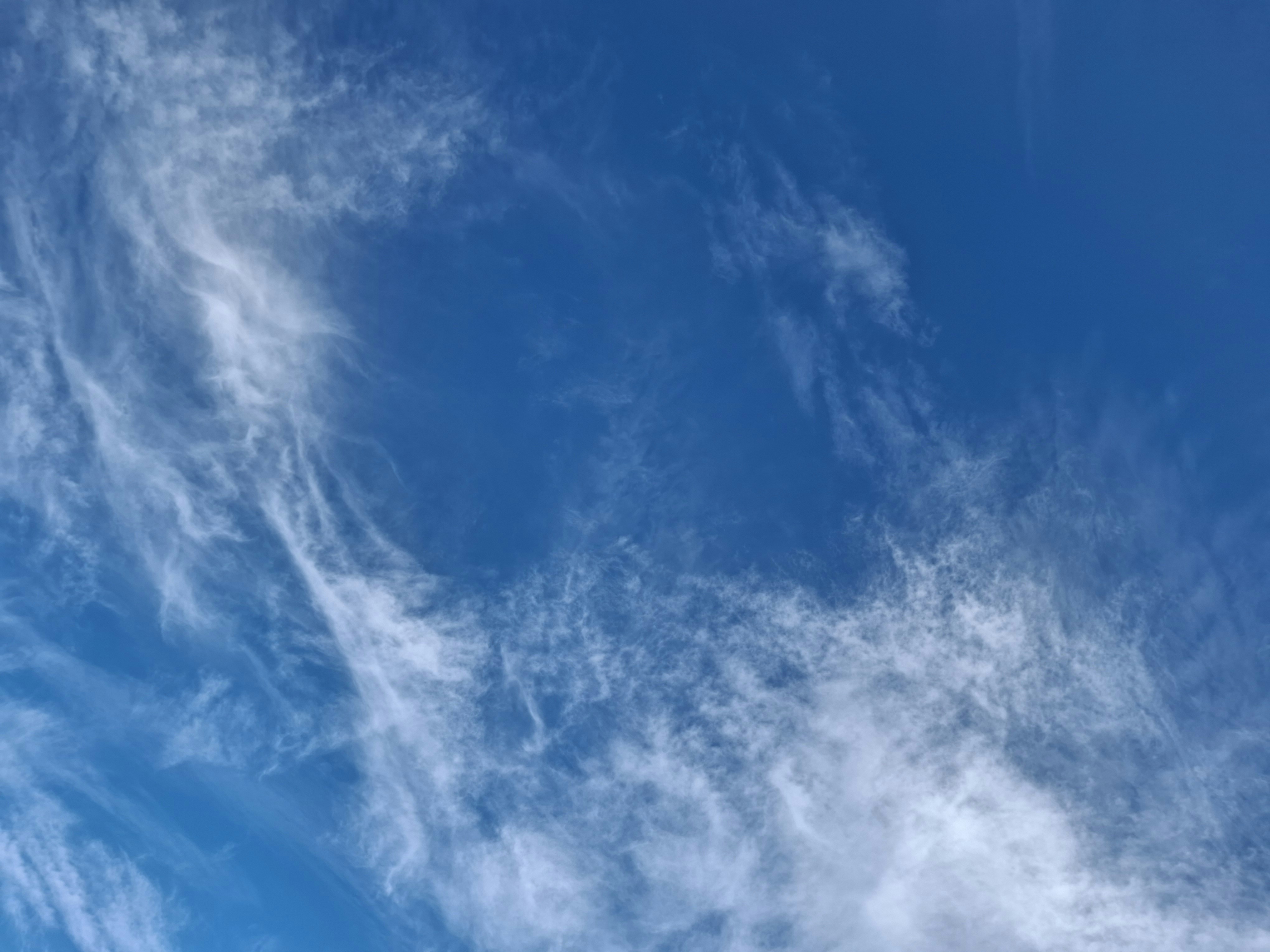 Azure Sky Whorl: Cloud Currents Across a Clear Day