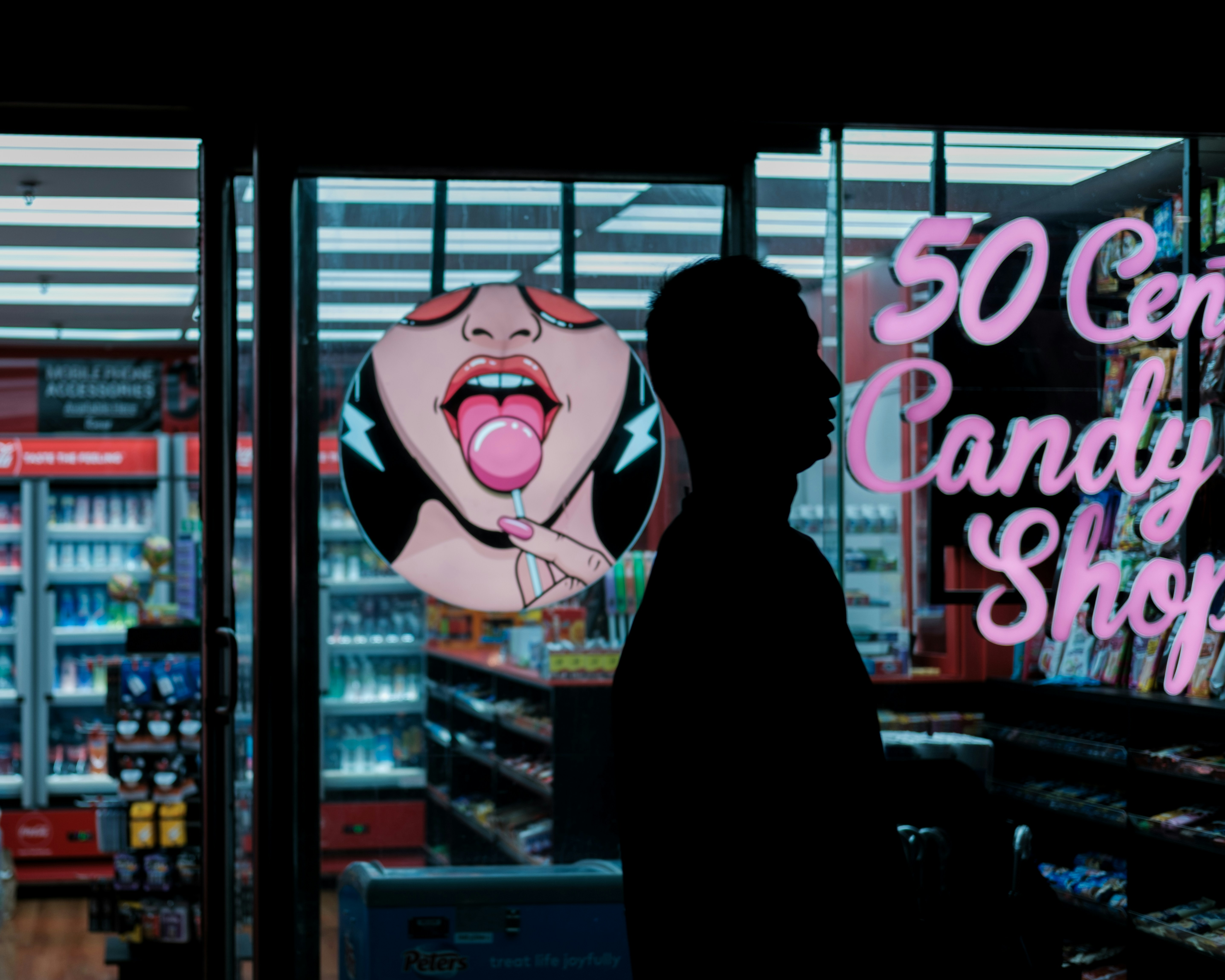 Neon Silhouette: A Lone Viewer Steps Through the Candy Shop Glass