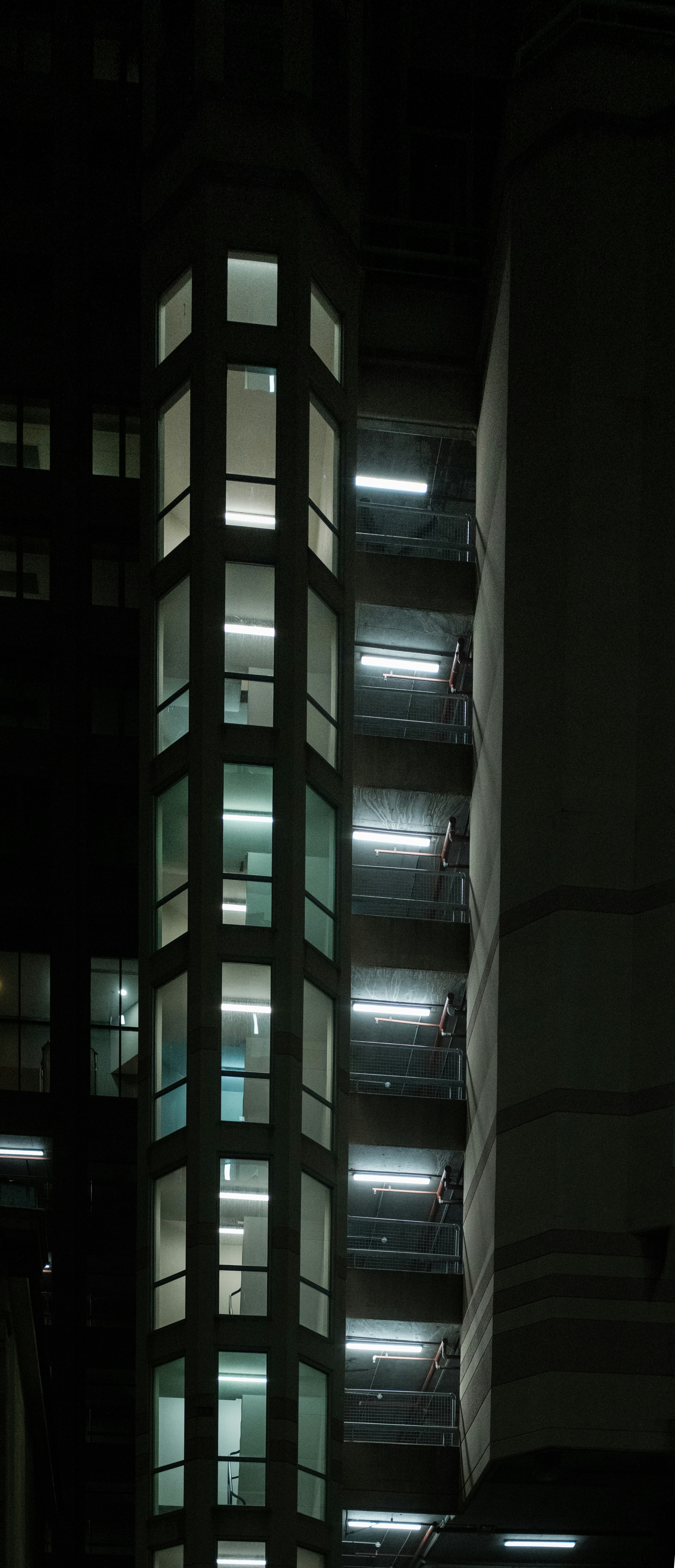 Vertical Core: Nighttime Elevator Atrium in Blue-Green Glow