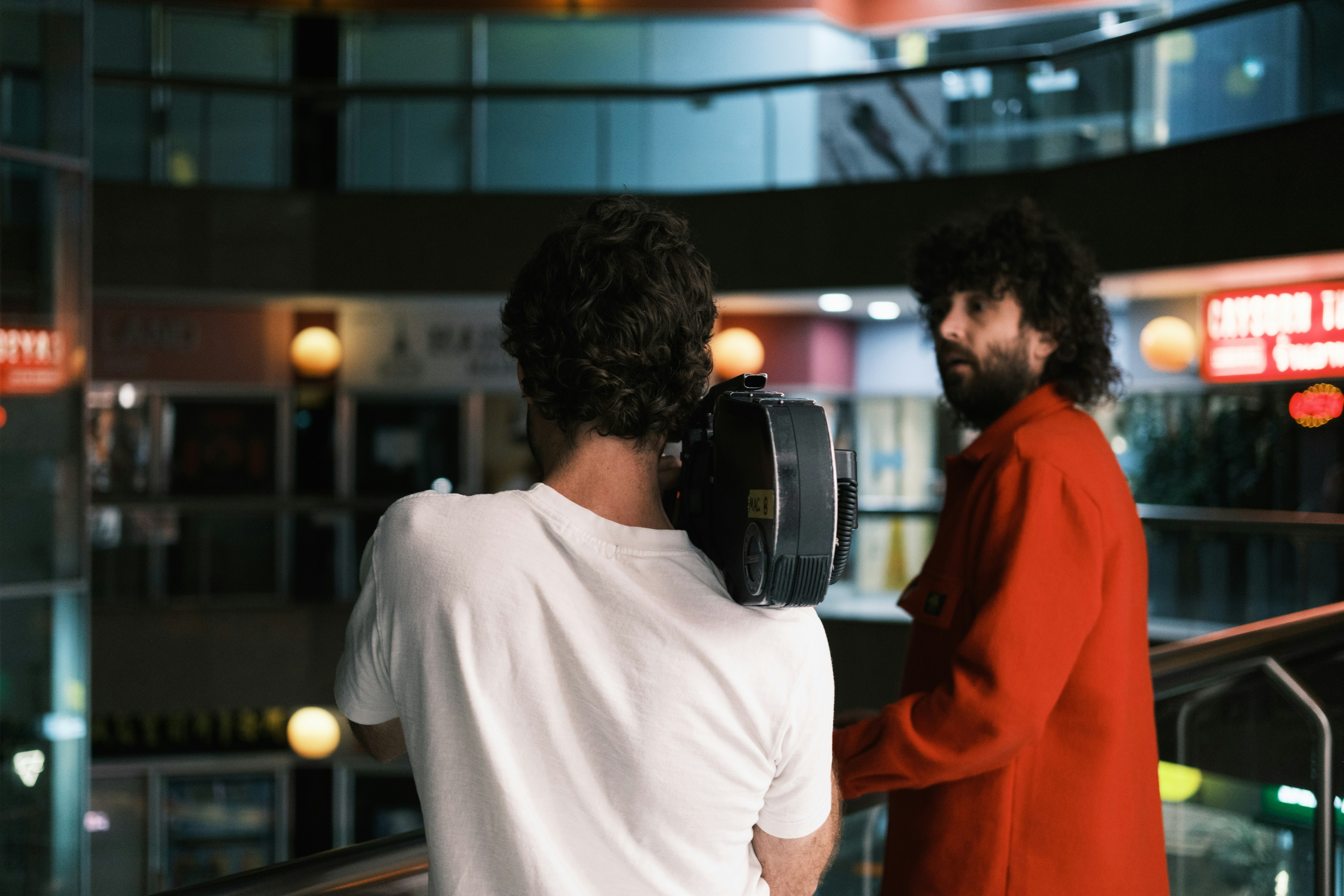 Two Camarades and a Glassy Gaze: Street Portrait in a Modern Atrium