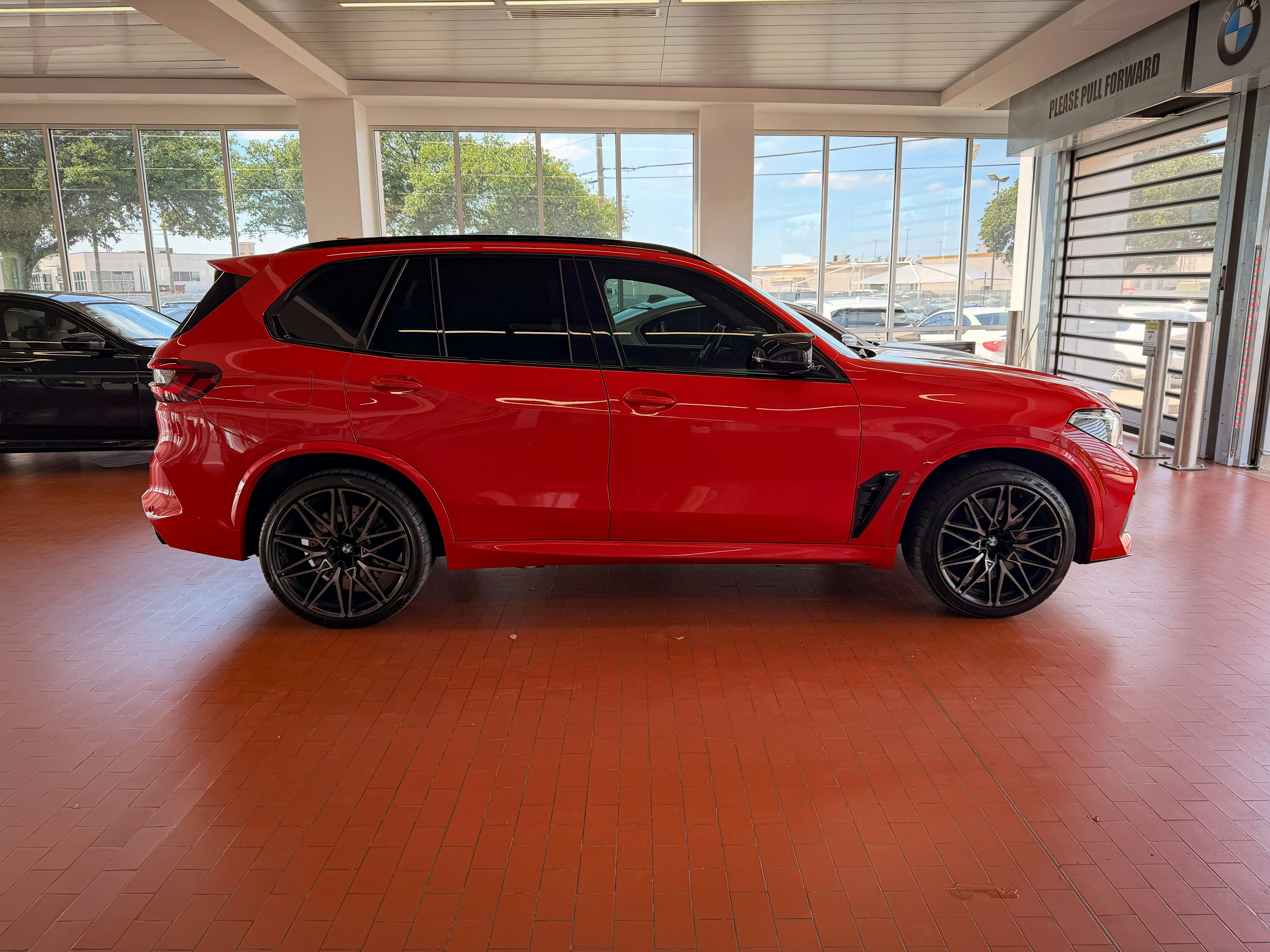 Red Rhythm: SUV Profile in a Sunlit Showroom