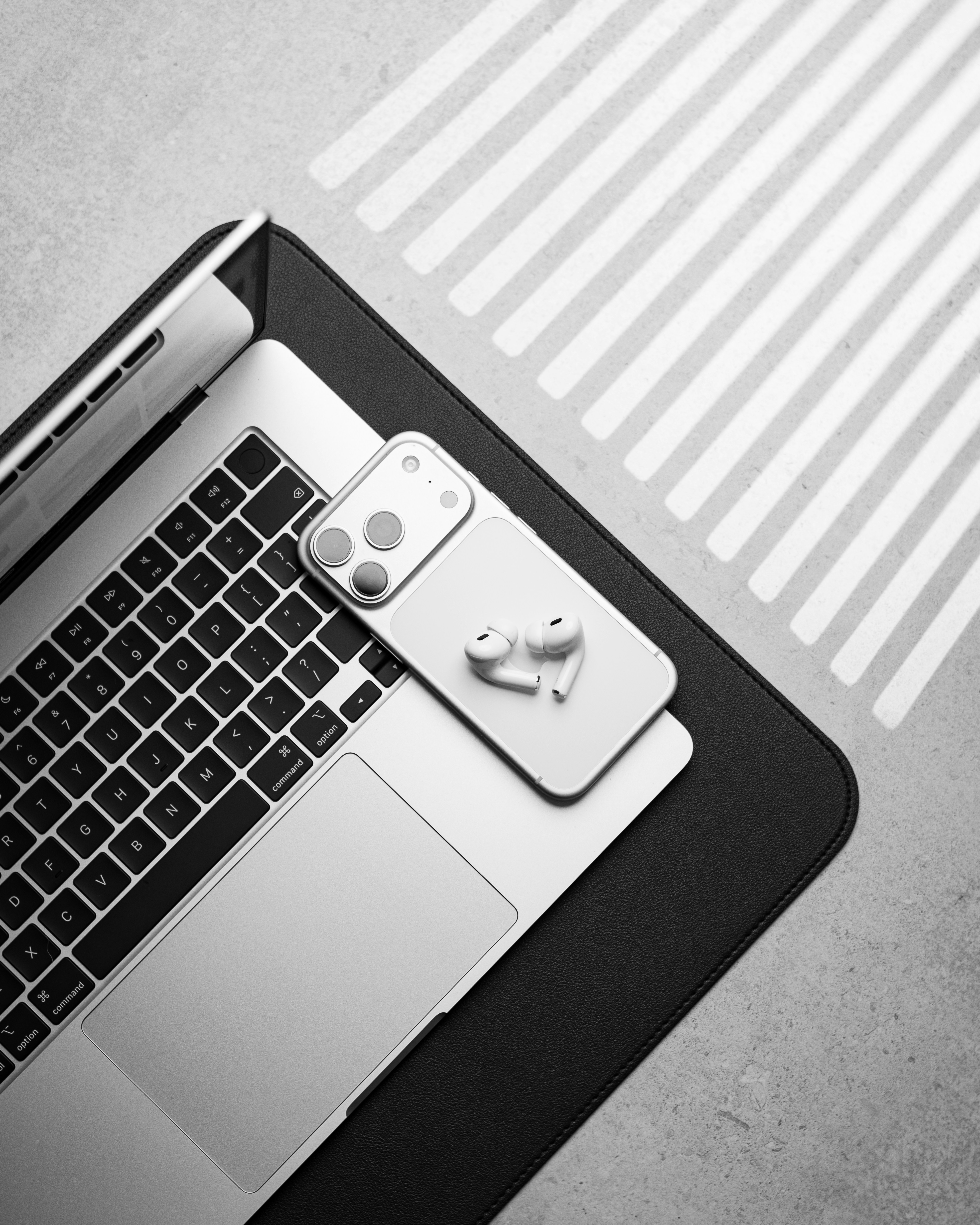 Neatly Arranged Tech: A MacBook Pro Nestled with AirPods Pro Case