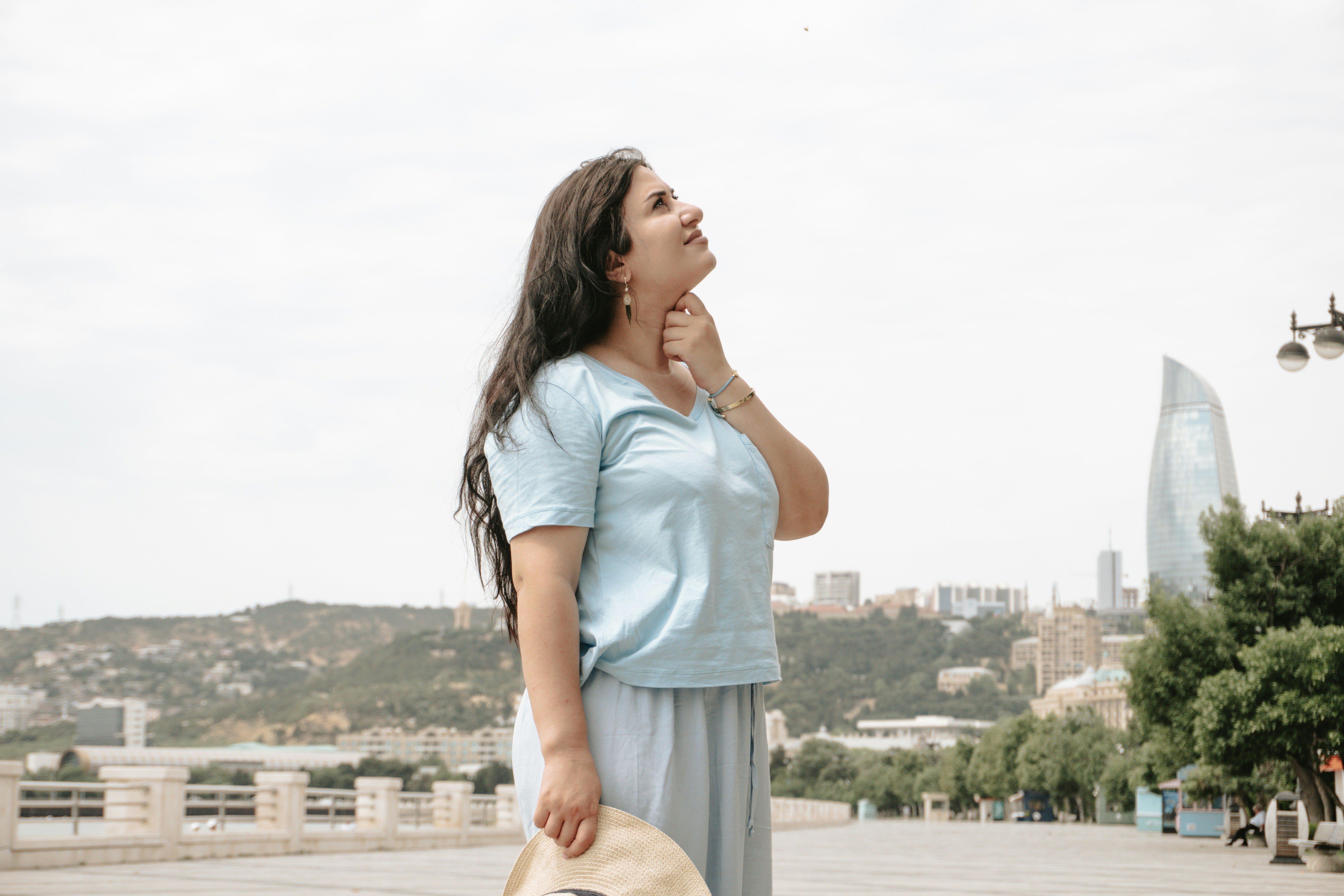 Bronzed skyline daydream: a woman in a pastel moment gazes upward
