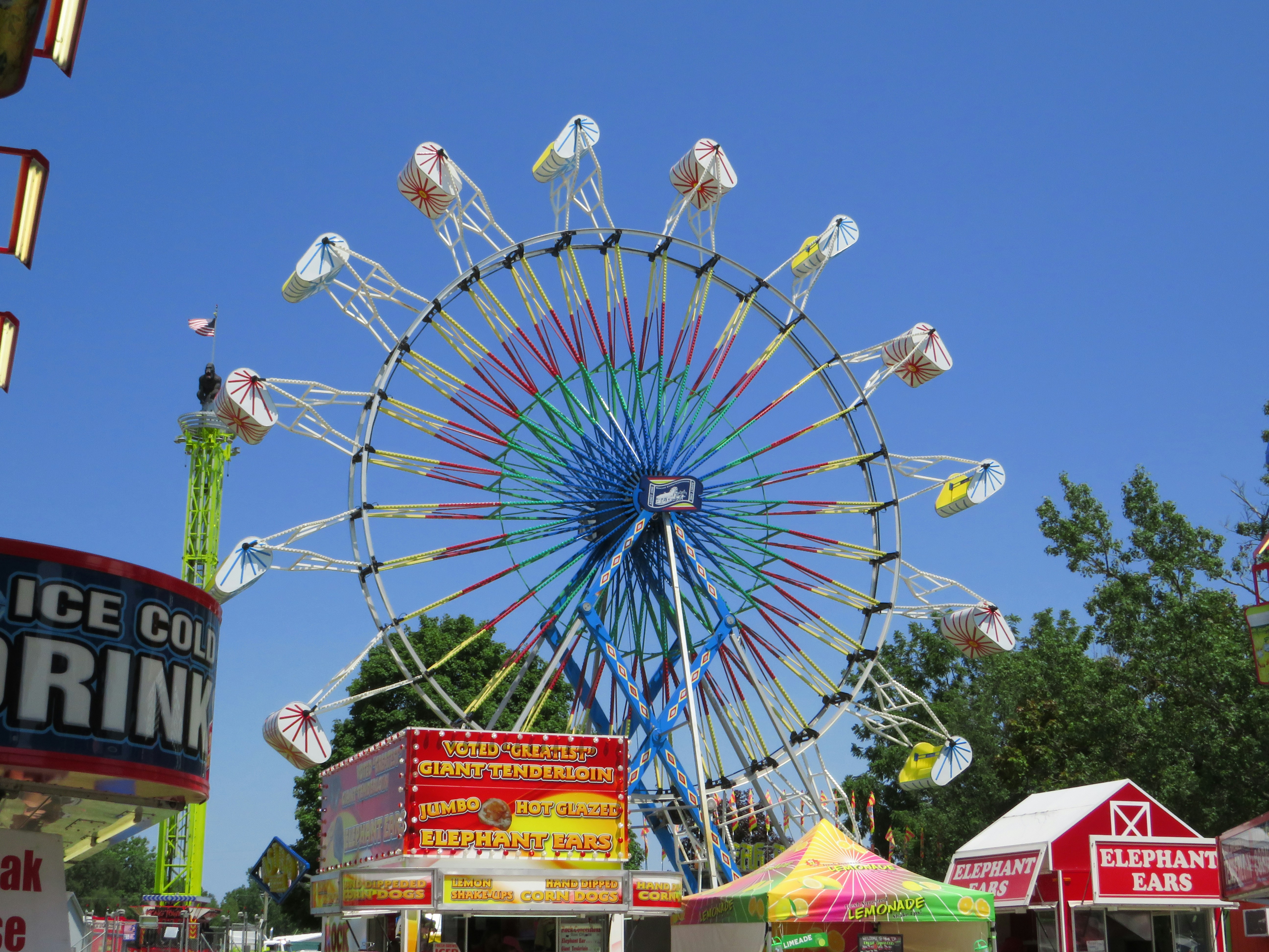 Rainbow Wheel Under Blue Sky: A Carnival’s Greying Giant