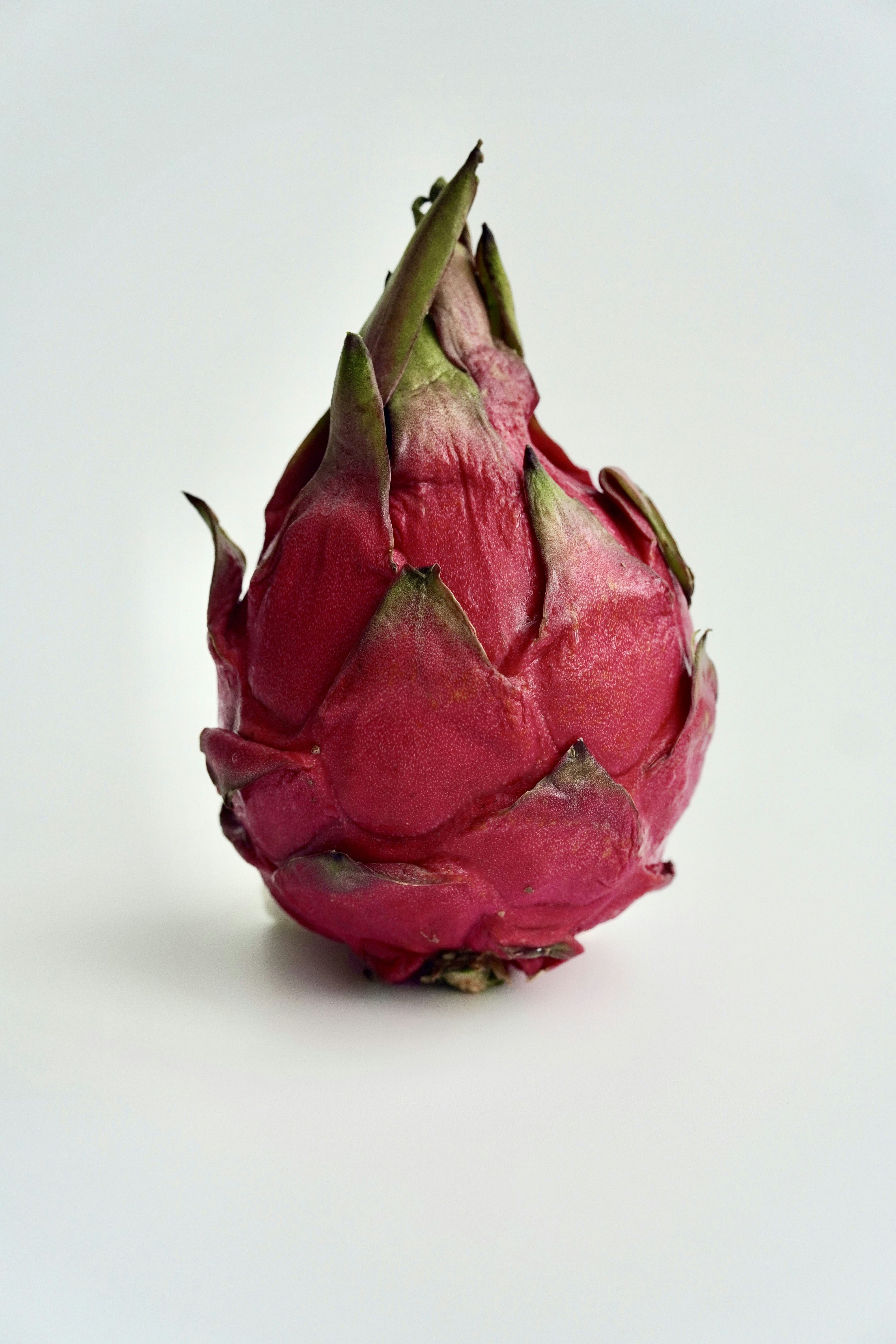 A vibrant pink dragon fruit on a white background.