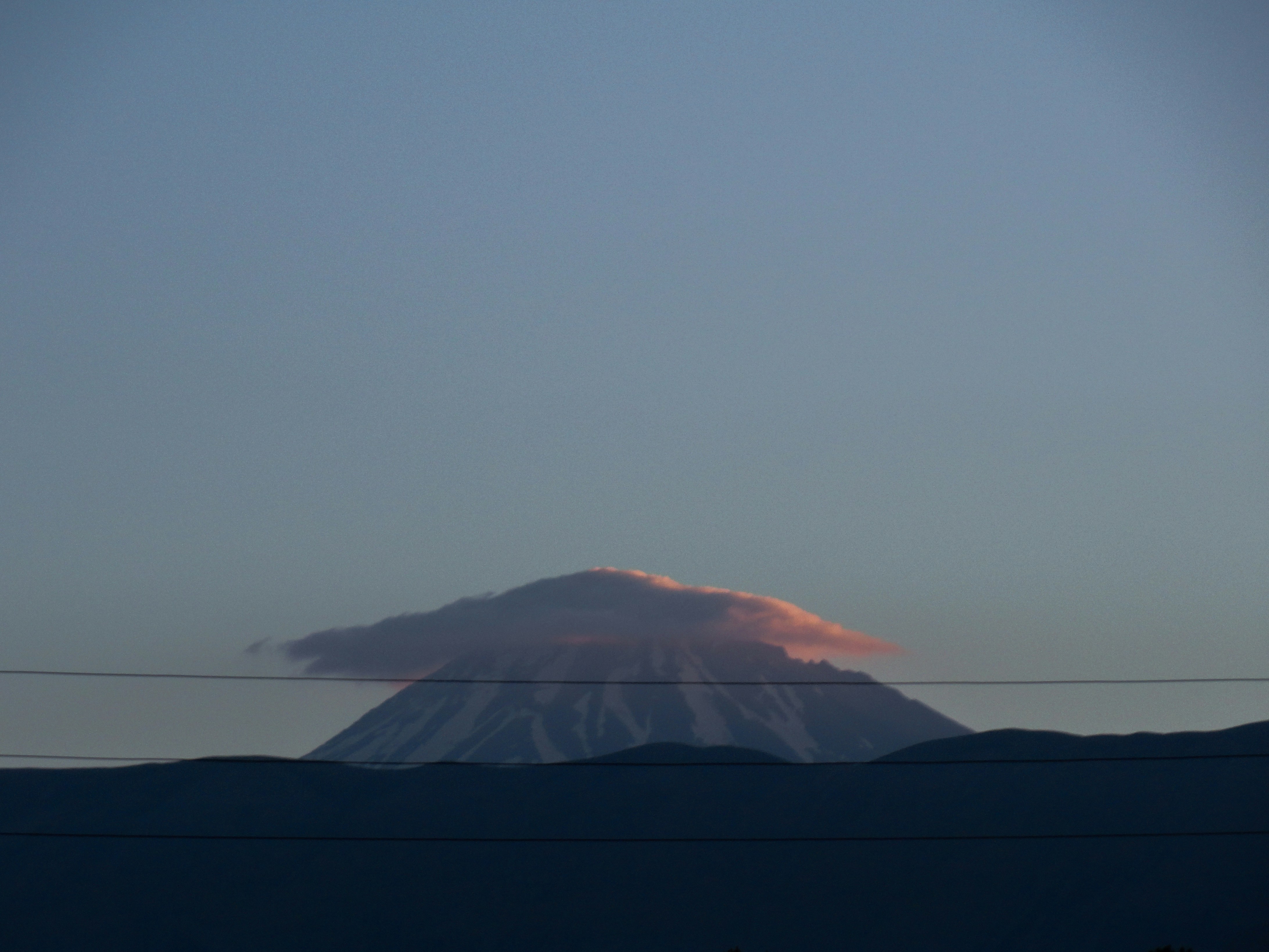 Dawn Over the Distant Volcano: Soft Light on Snow-Capped Summit