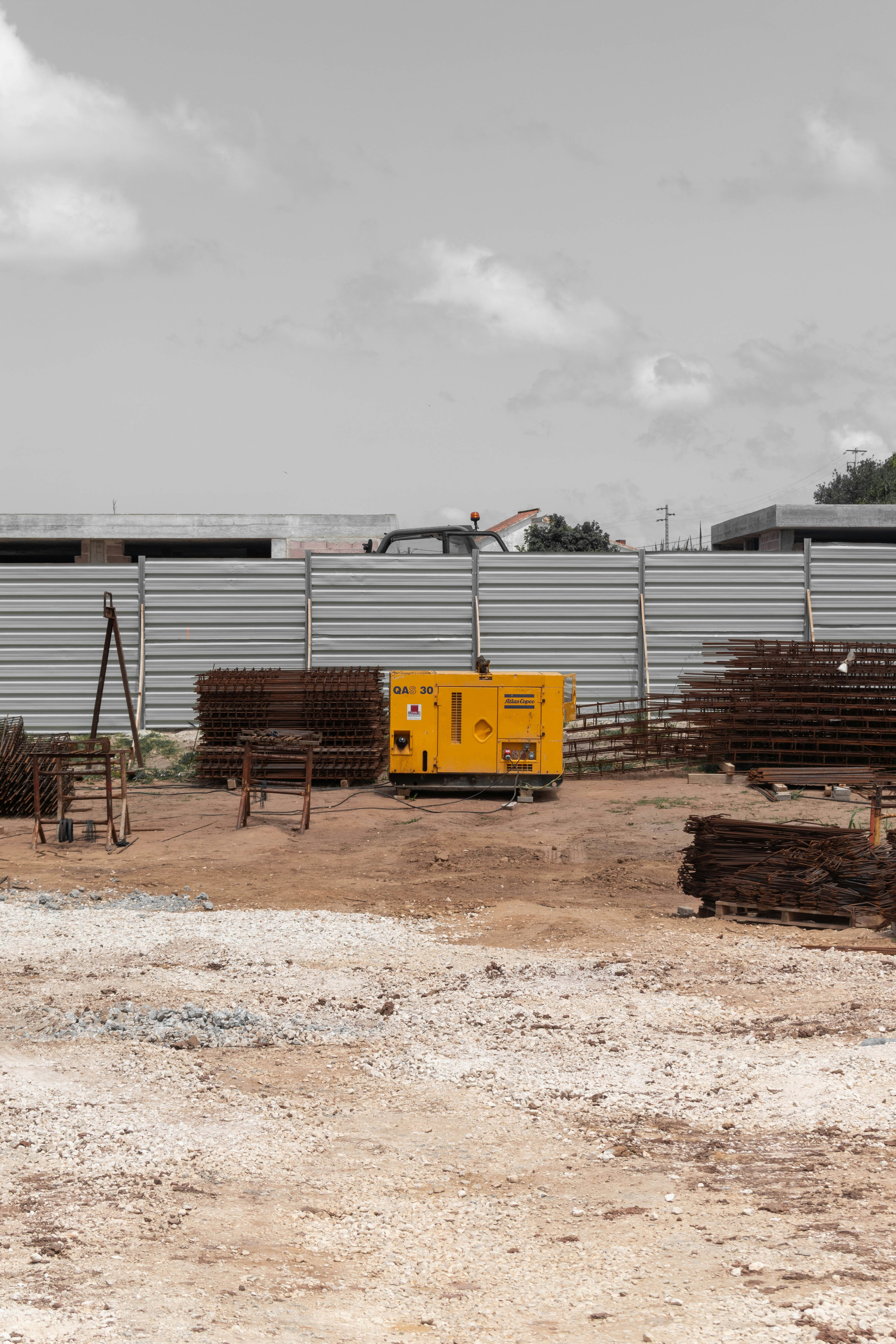 Yellow Generator on a Construction Site Amid Stacked Rebar