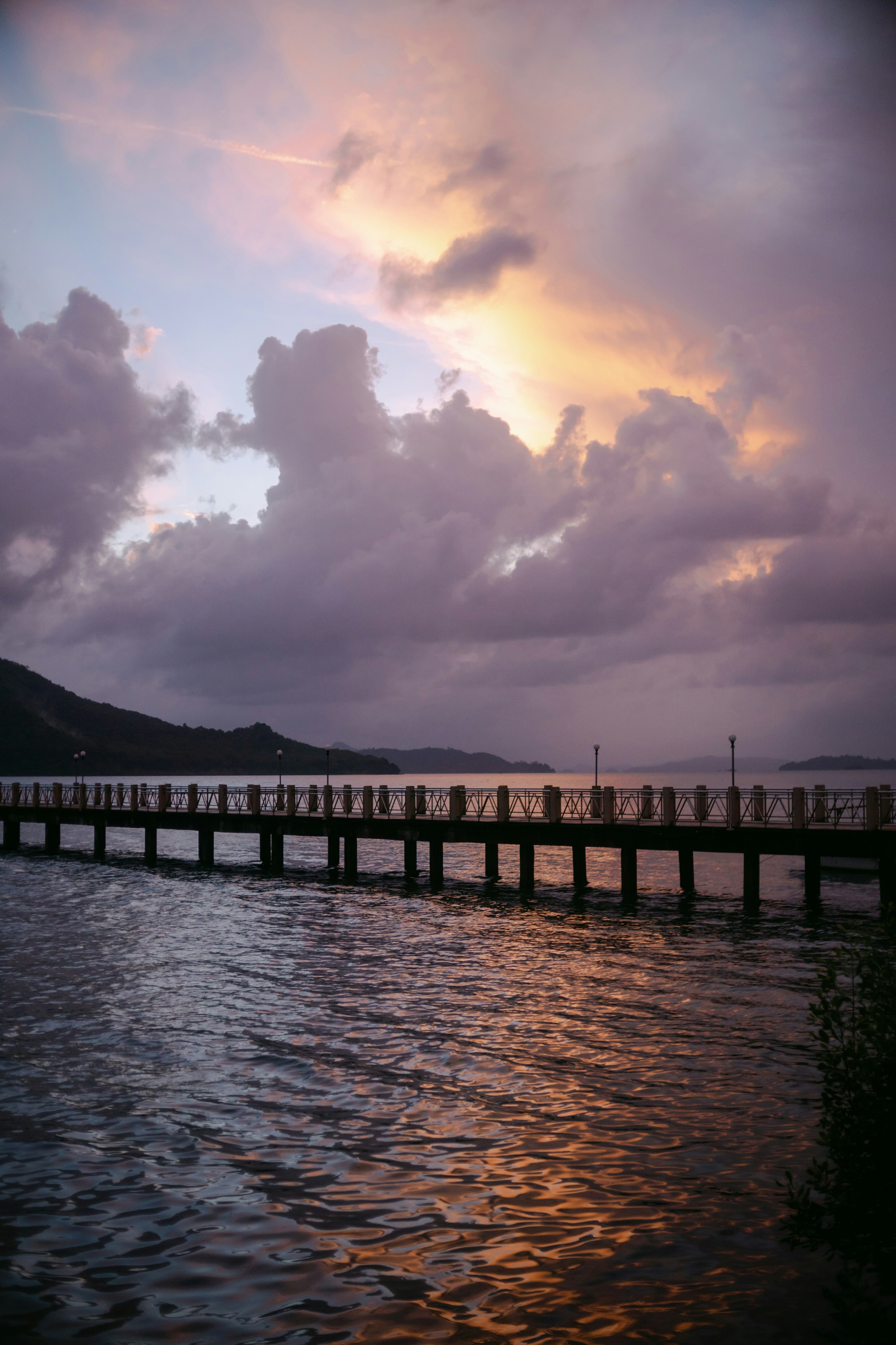 Sunset Pier Over Water: Quiet Horizon Beneath Crimson Clouds