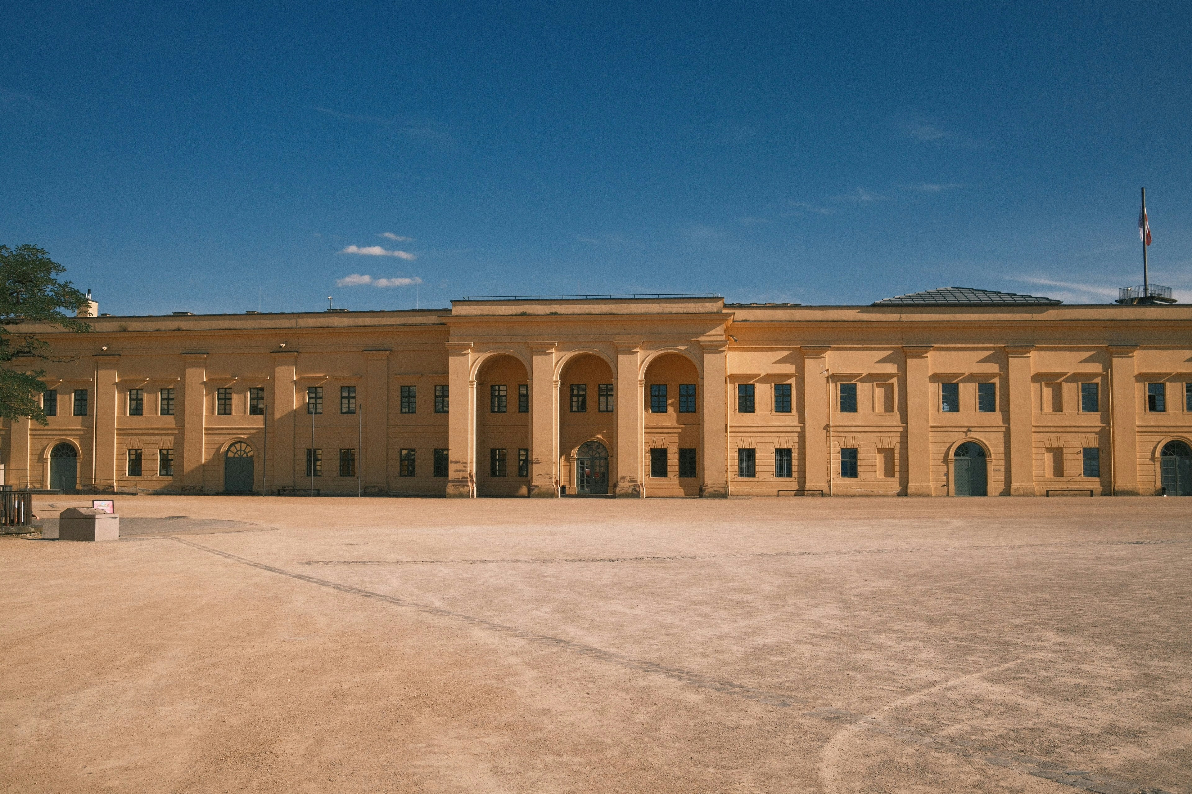 Symmetrical neoclassical facade under a clear afternoon sky