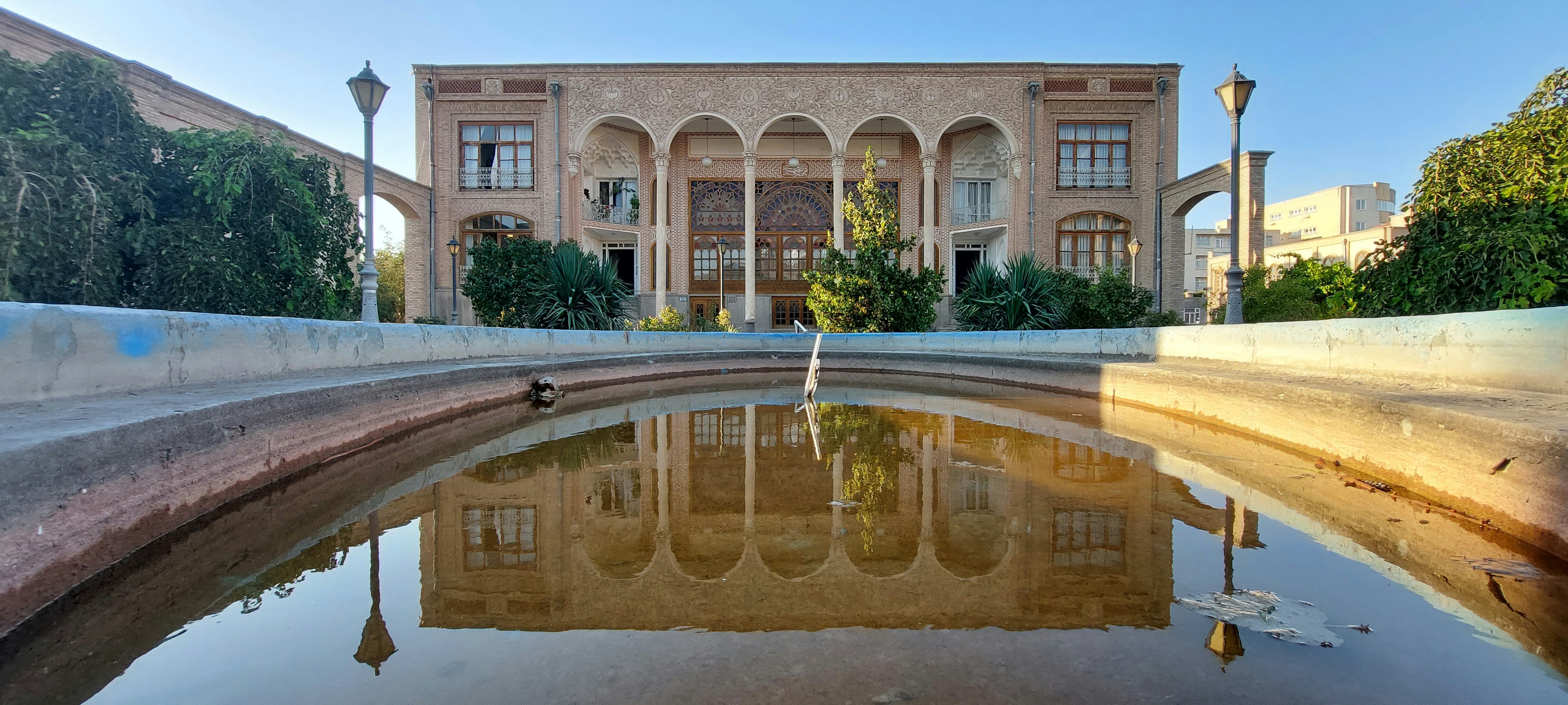 Symmetrical Authority: A Historic Courtyard Fountain Framed by an Arching Facade