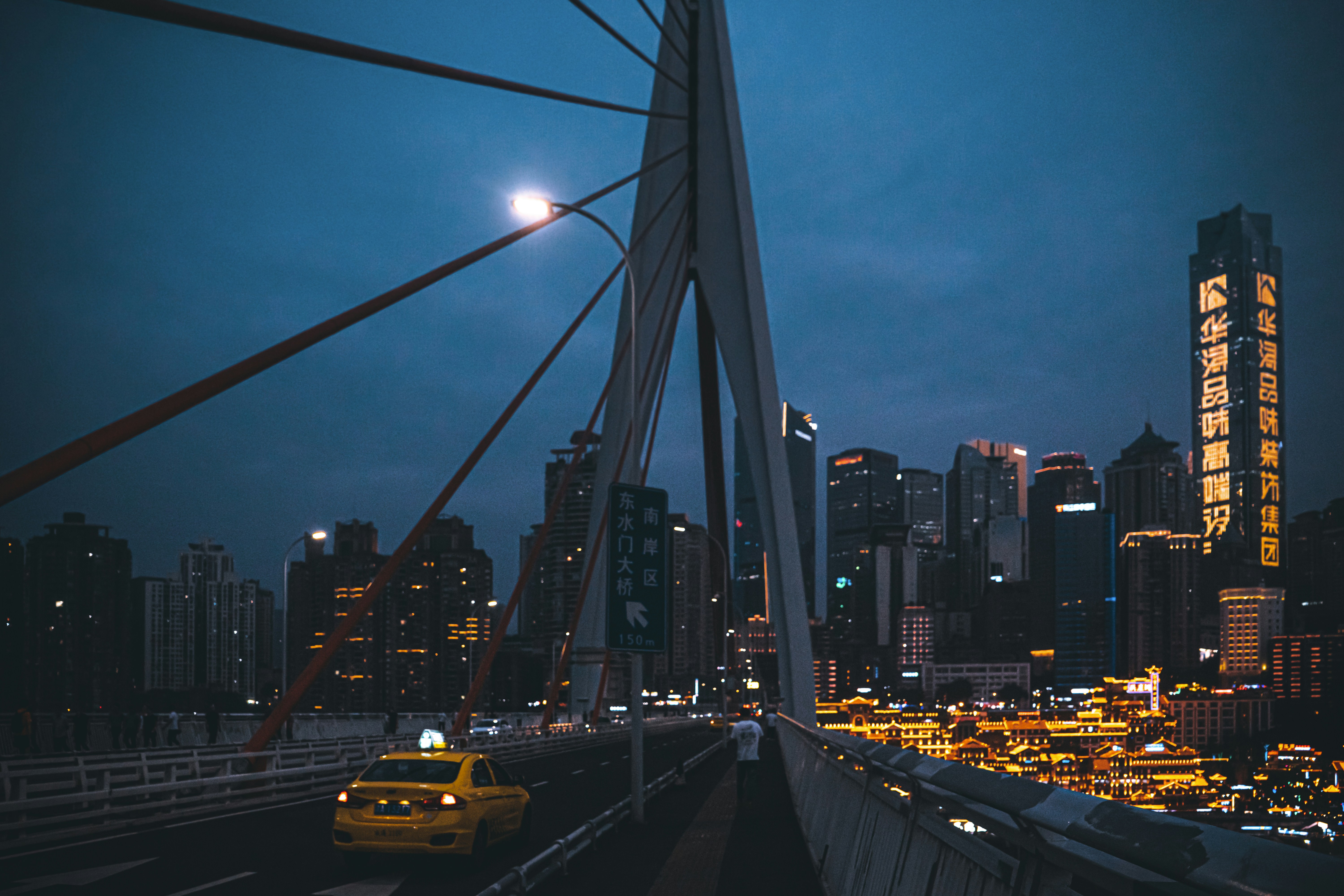 Neon Arc Over the City: Night Ride on a Cable Bridge