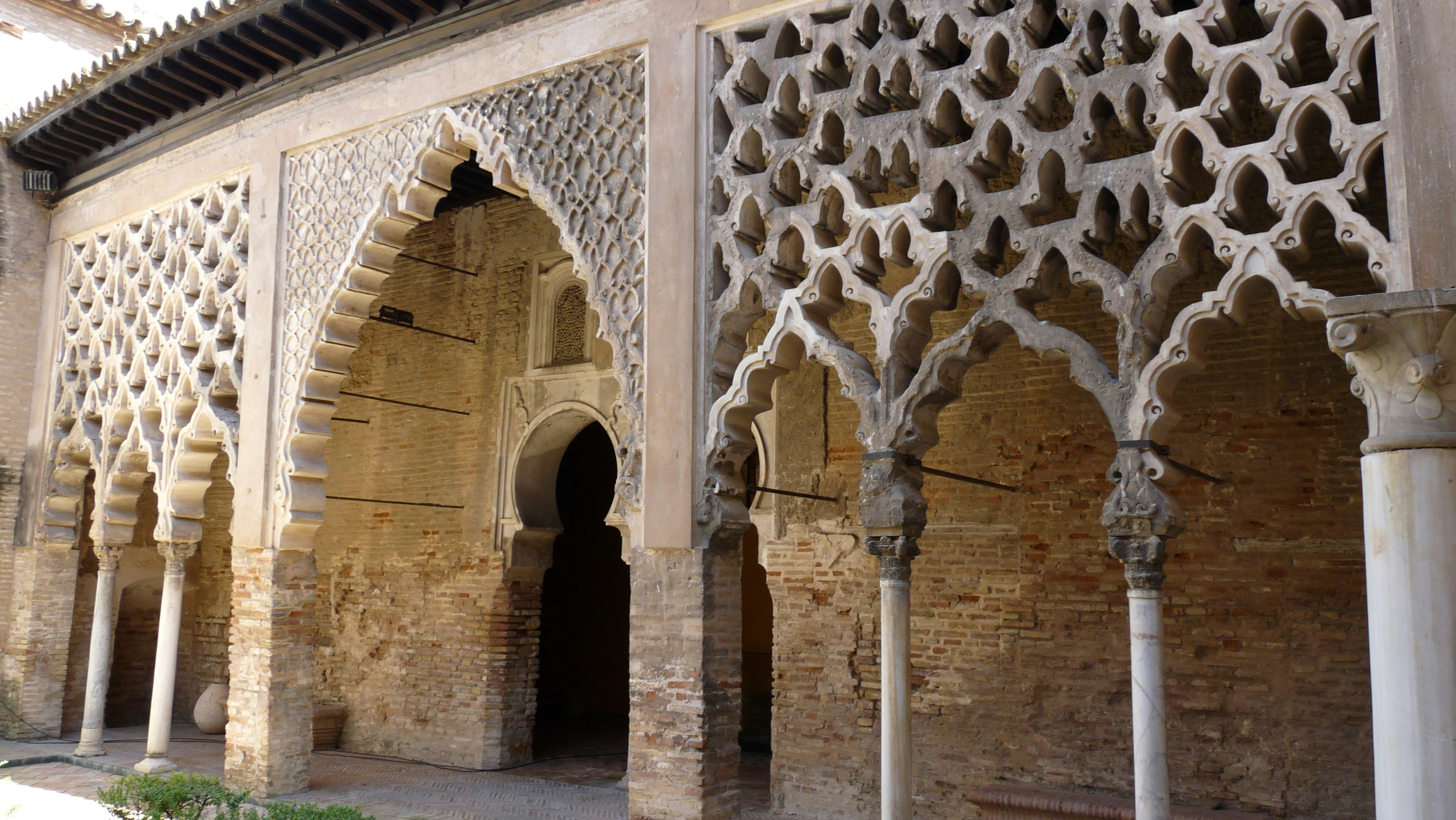 Carved arches and sunlit brickwork of a Moorish arcade