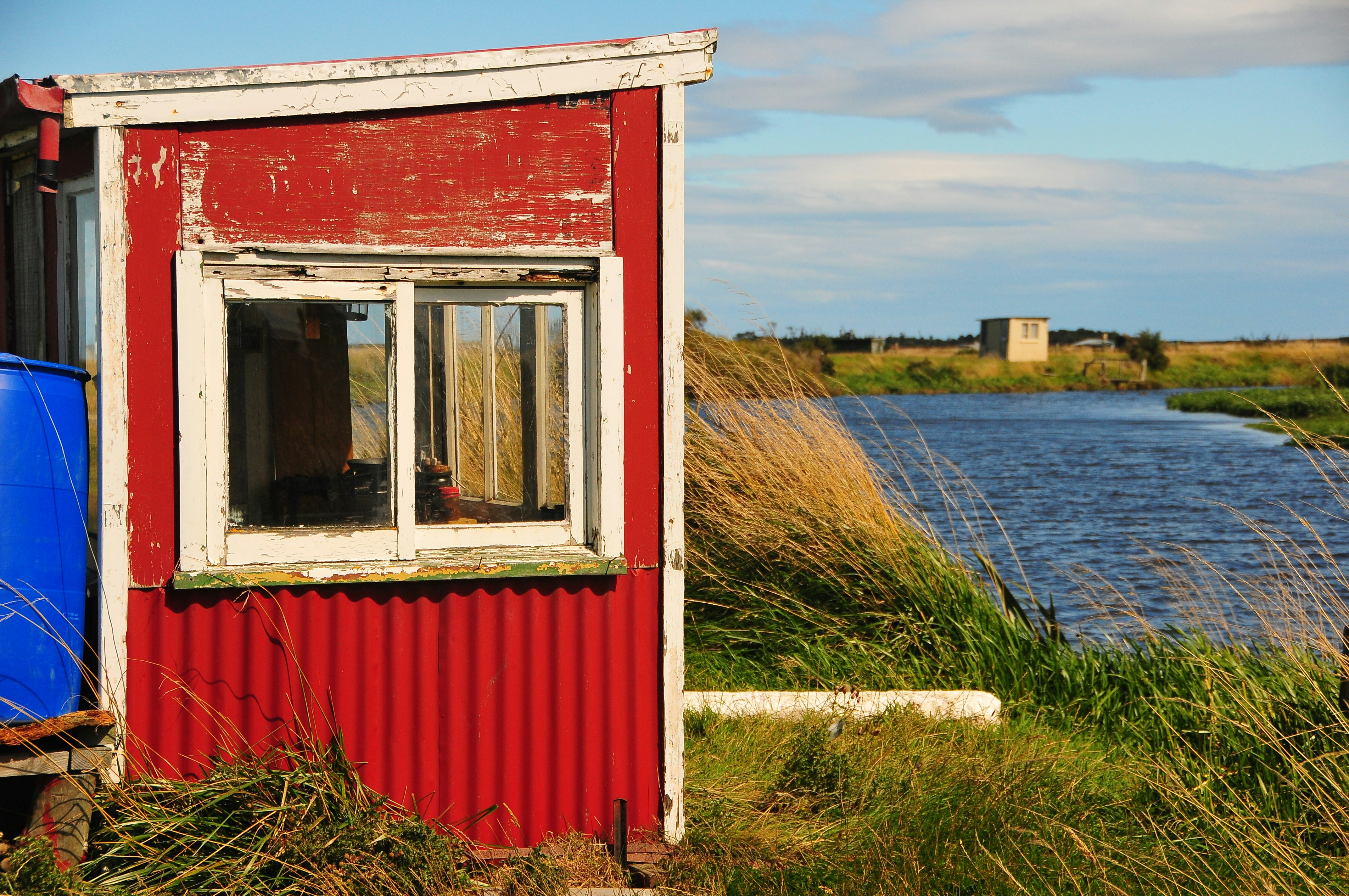 Red Shuttered Hut by the Quiet Estuary