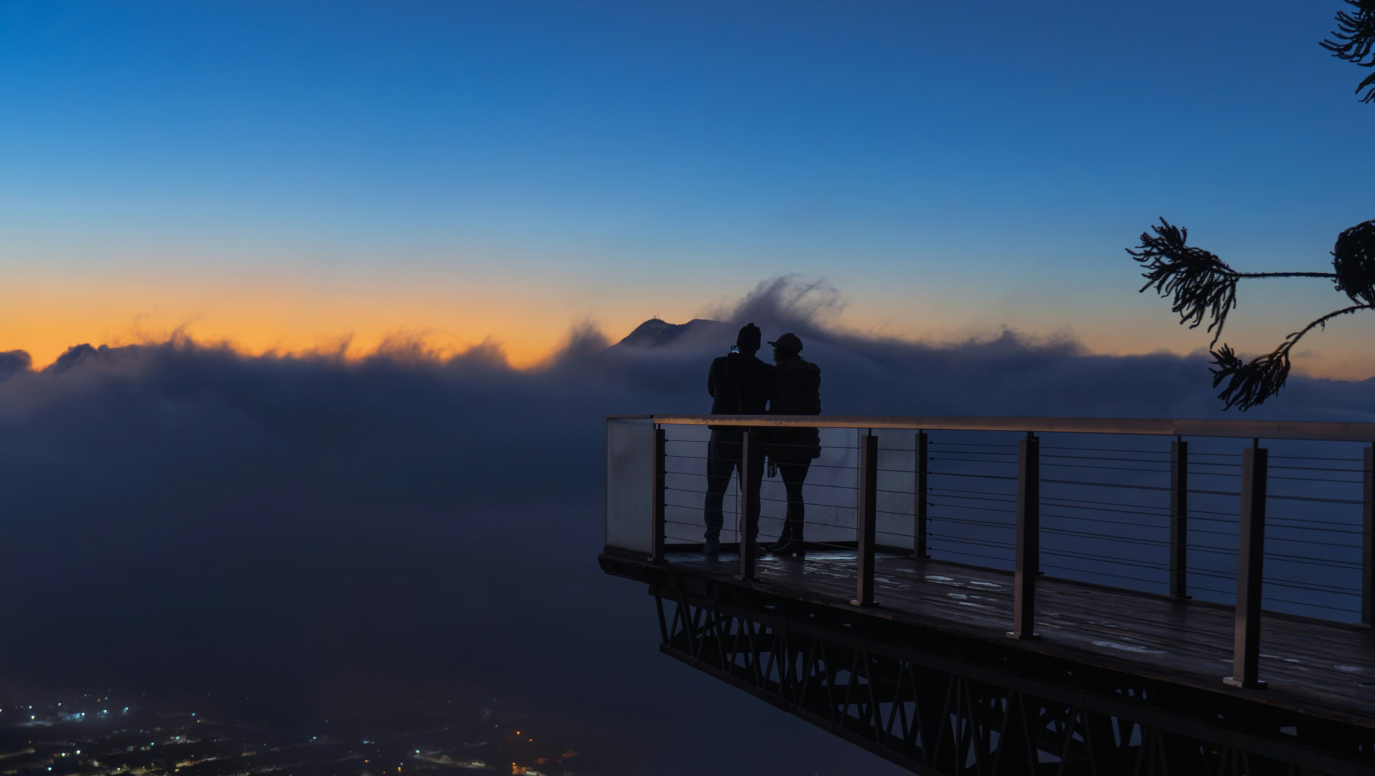 Two Silhouettes at the Edge: Dawn Over the Clouds