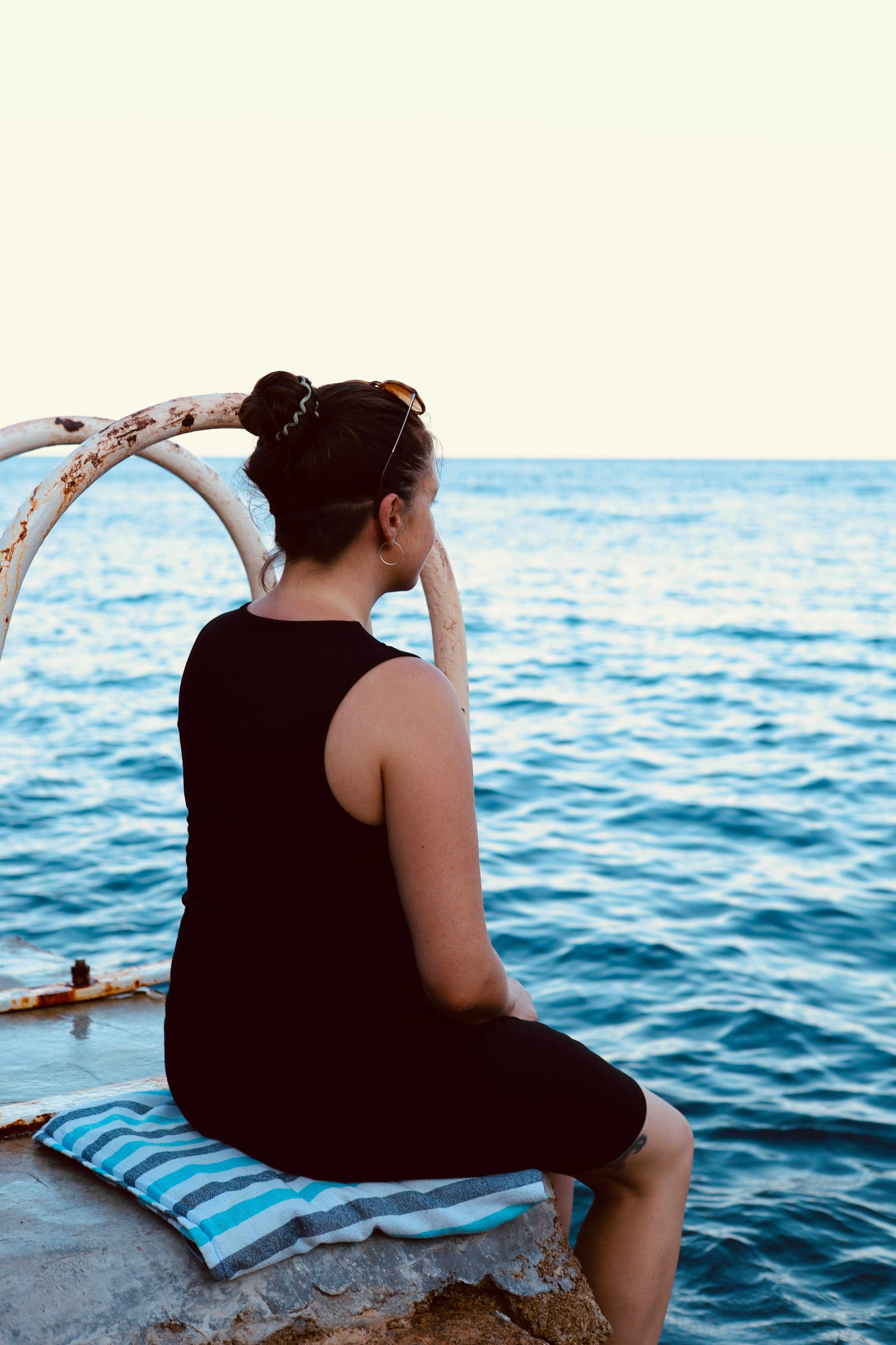 Solitary Moment at Sea: A Woman Sitting by the Horizon