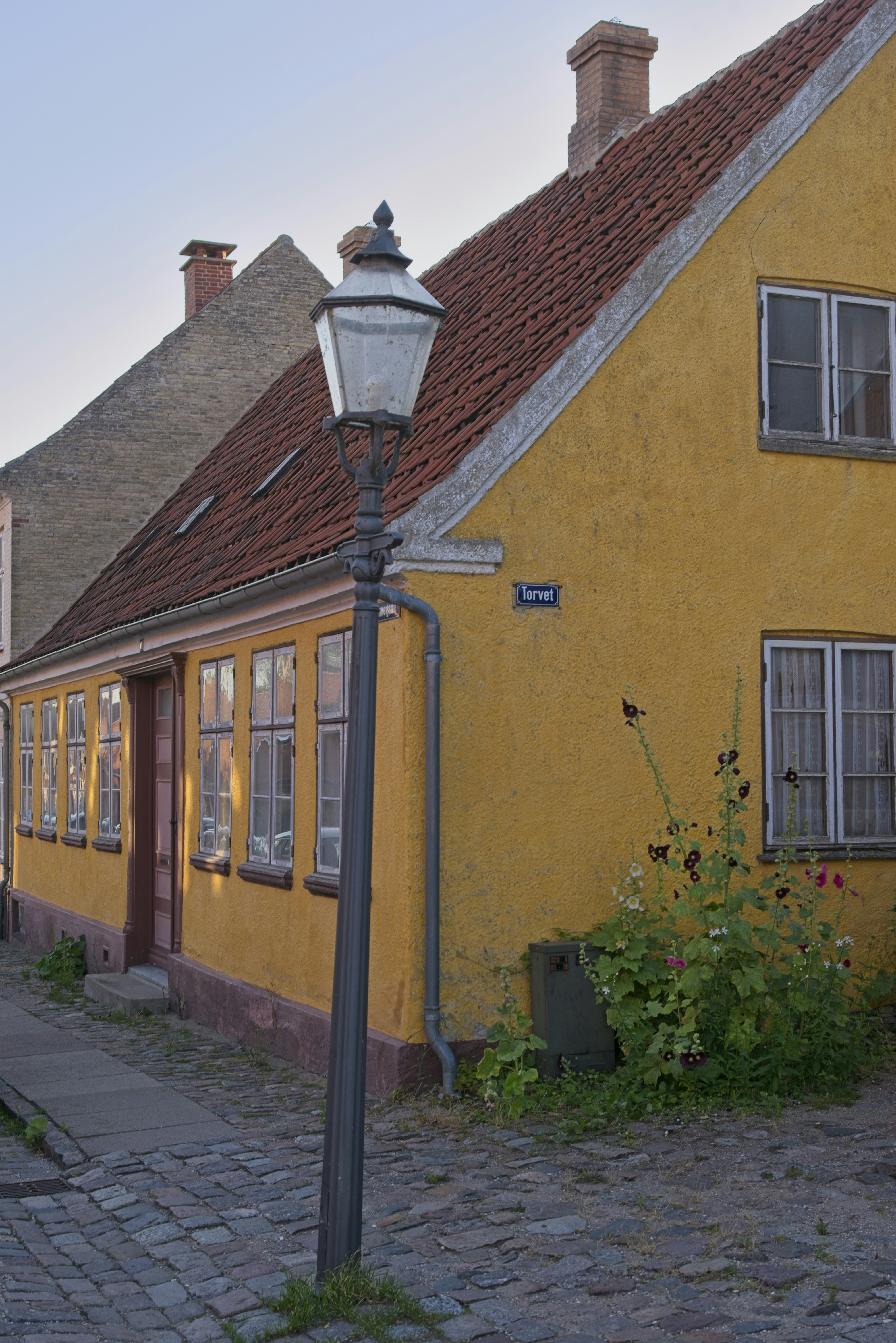 Yellow House on Cobblestone Lane under a Quiet Evening Sky