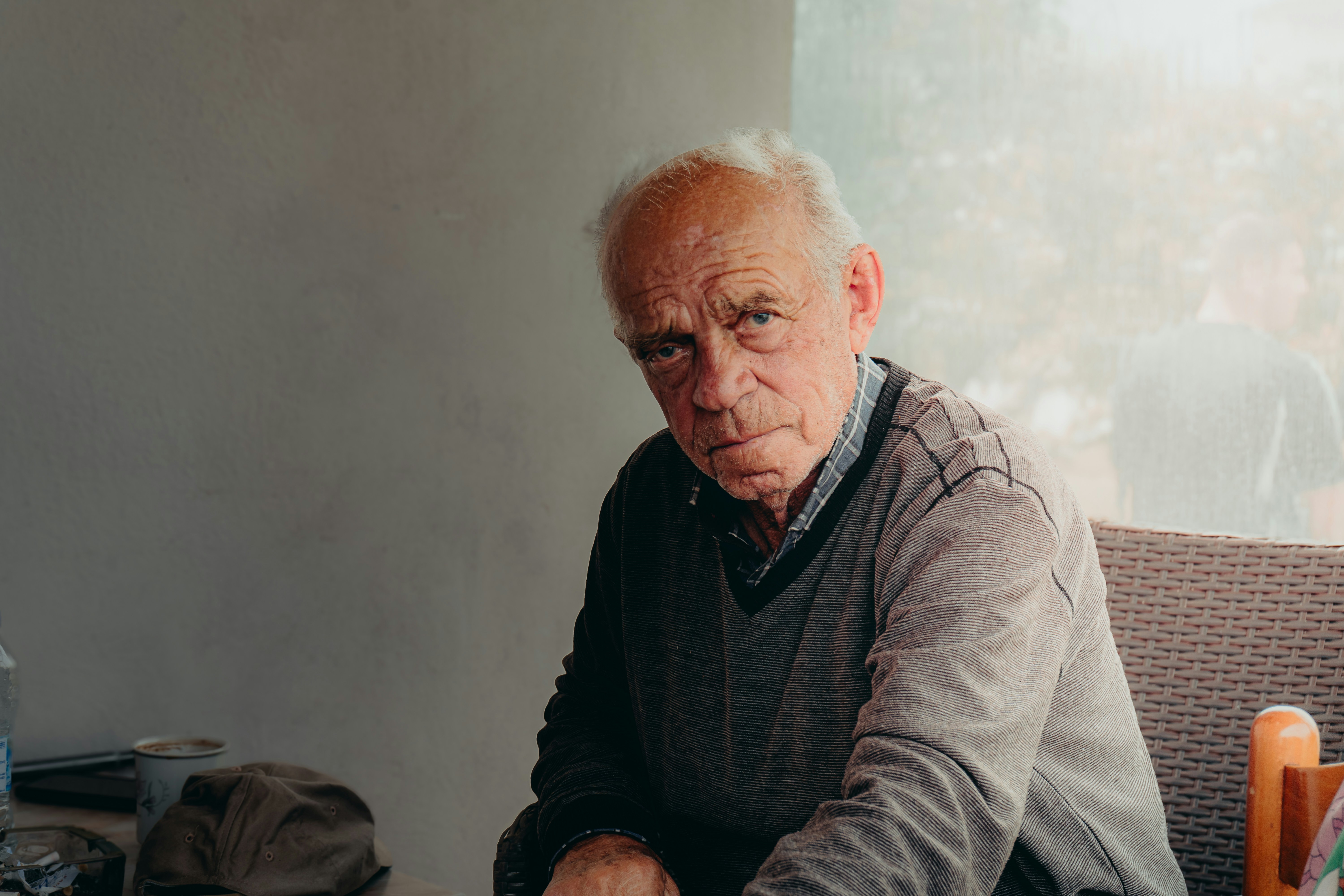 Quiet Contemplation at Dusk: An Elderly Man in Soft Interior Light