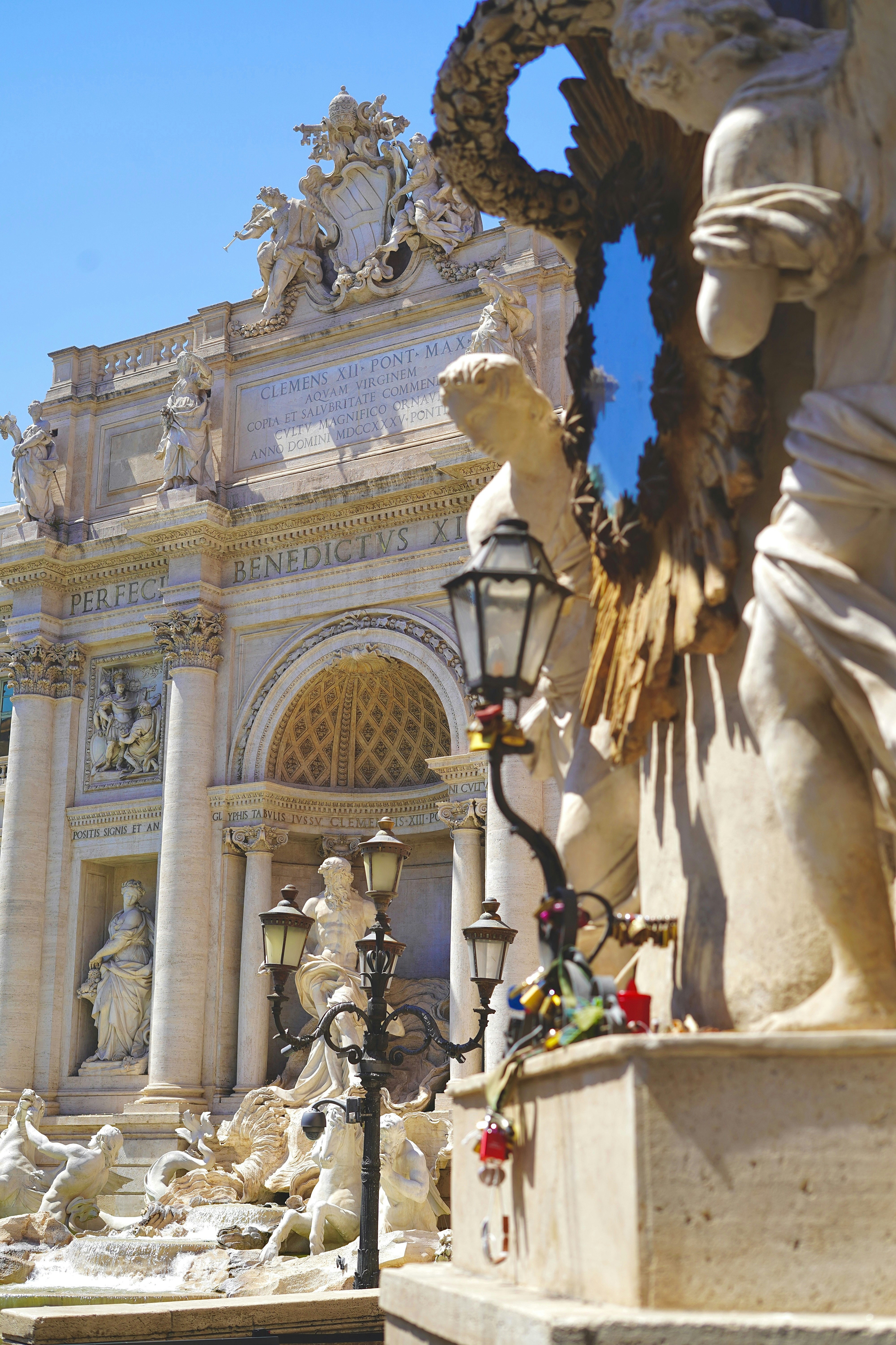 Neoclassical facade framed by winged guardians and street lamps