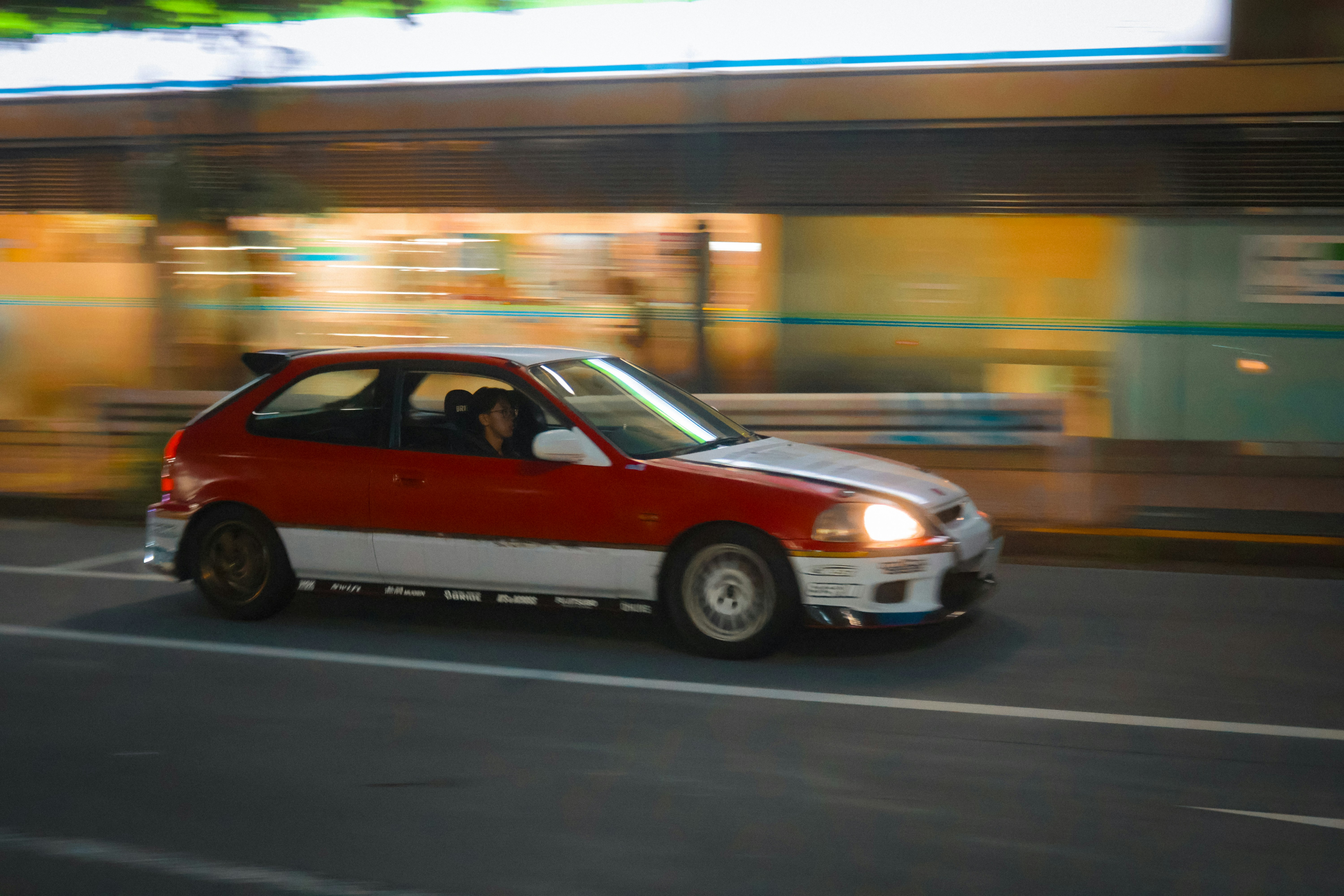 Blurry Red Hatch: Motion Through Evening Streets