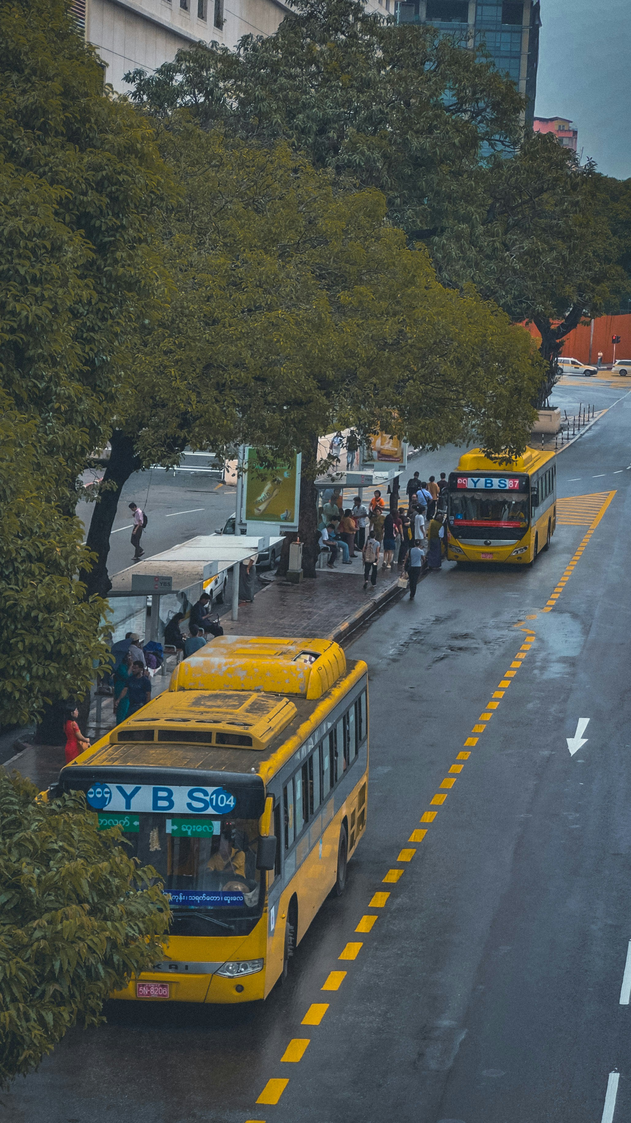 Yellow City Bus Lines Down a Busy Urban Road