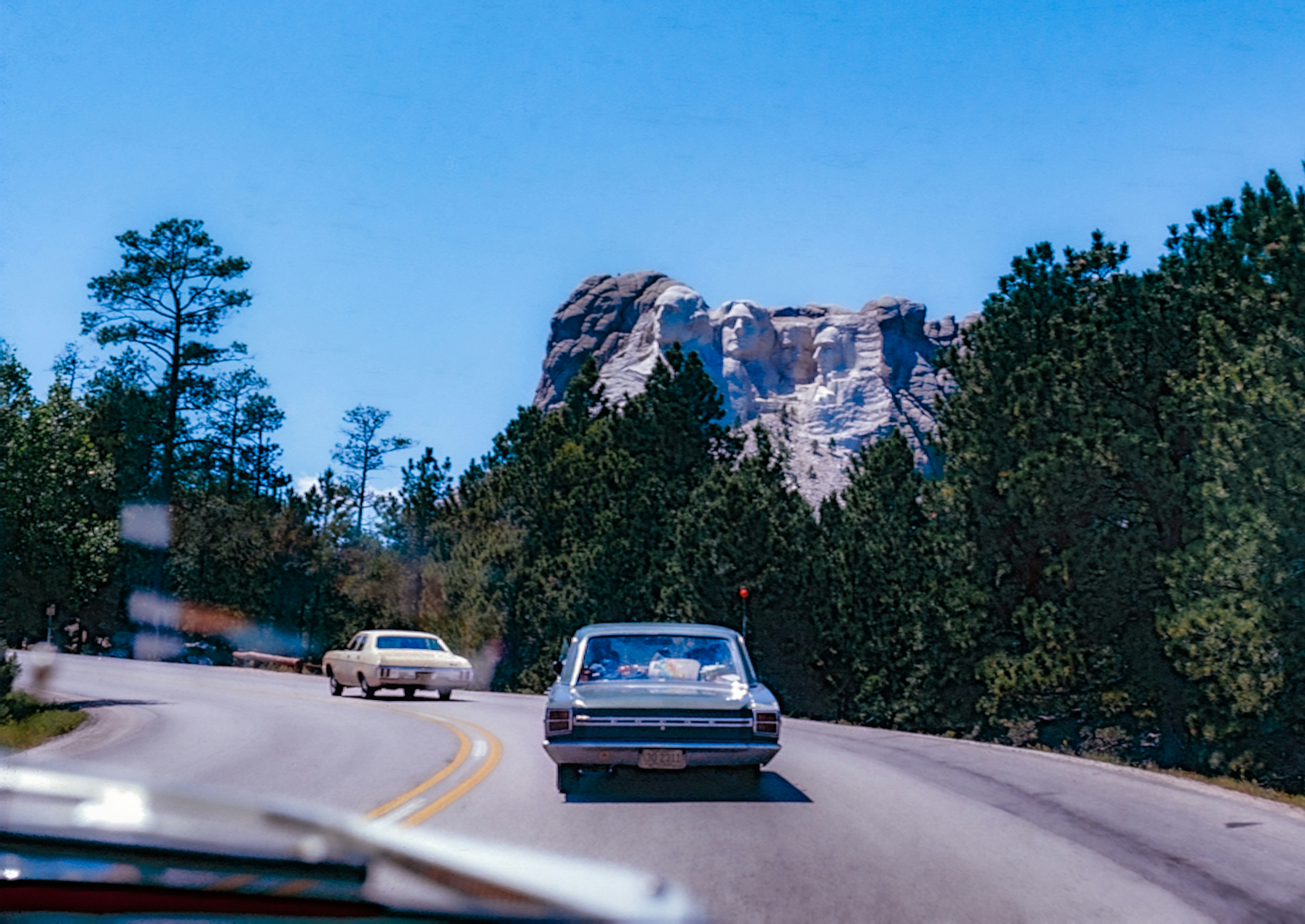 Mid‑Curve Escape: Classic Cars Down a Windy Mountain Boulevard