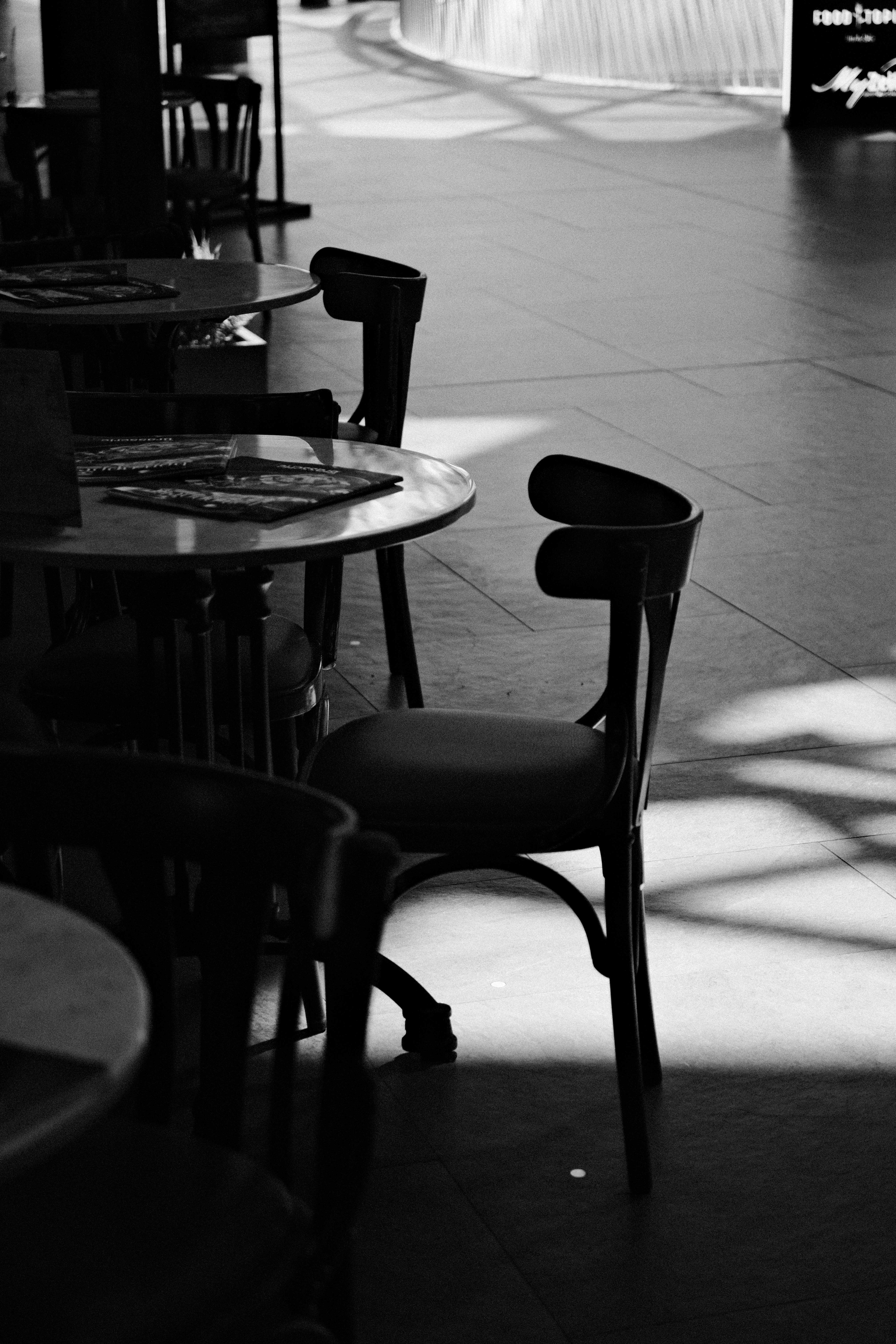 Shadowed Bistro: Empty Chairs under Striped Light