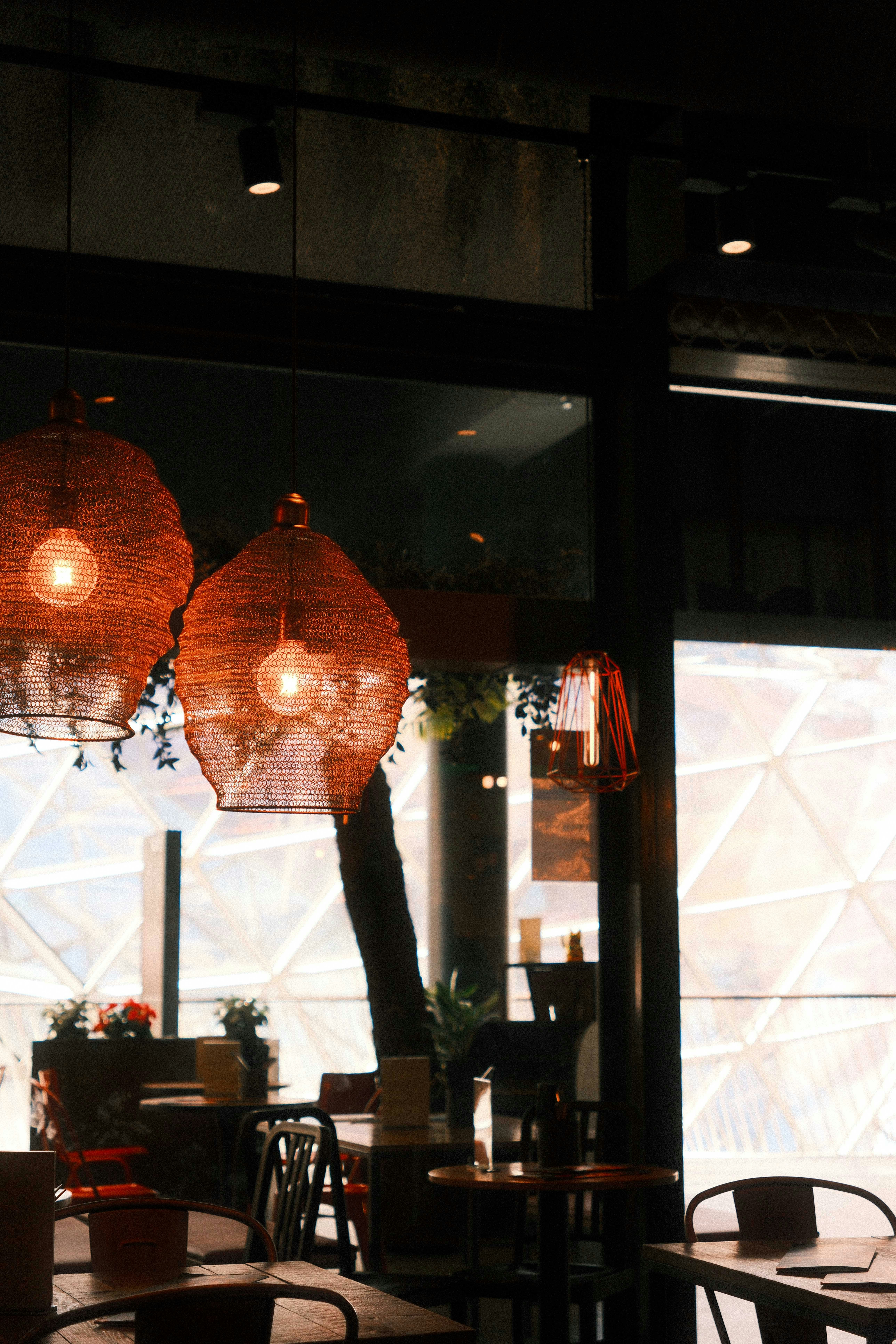 Warm ambient cafè glow under woven pendant lights