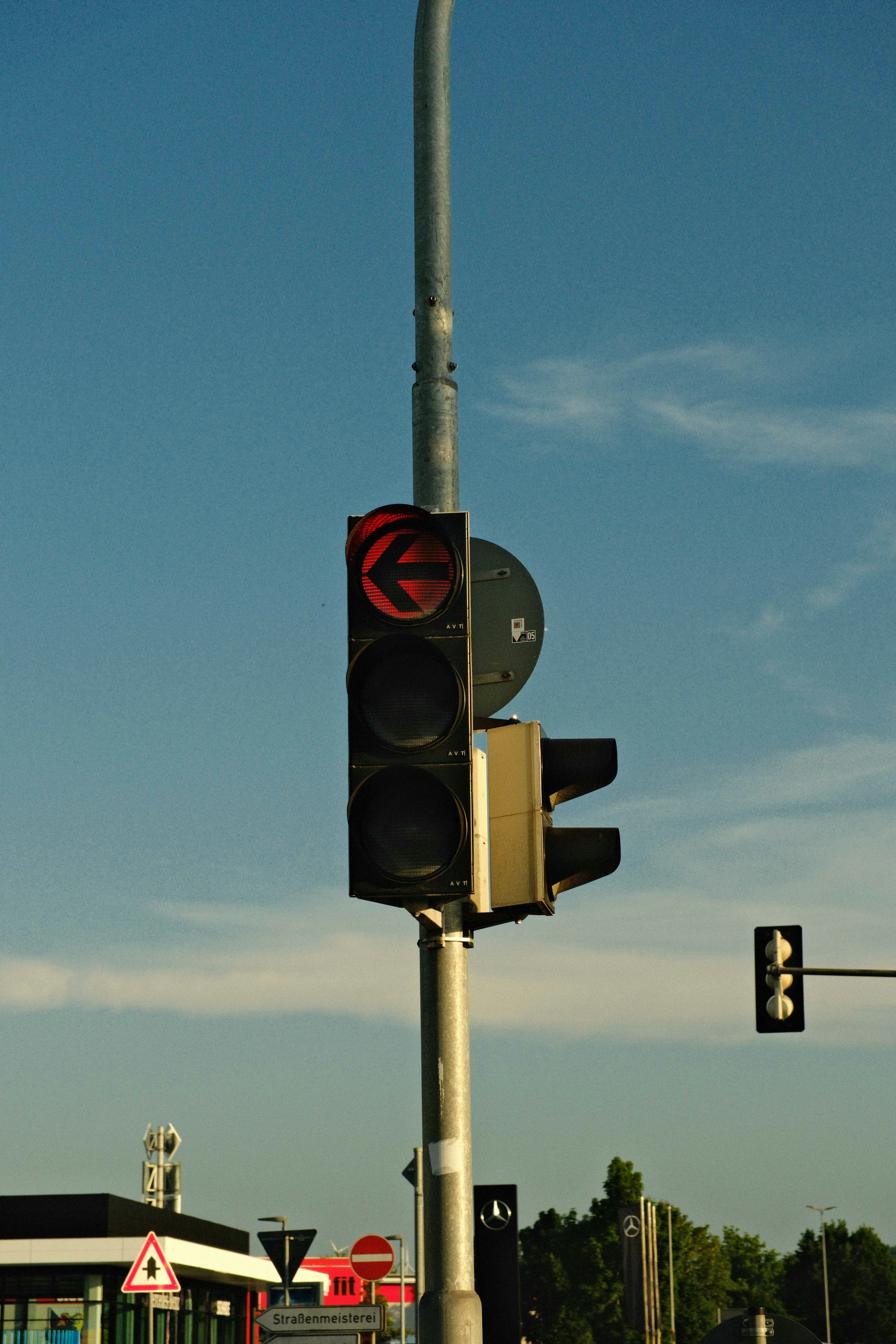 Urban Signal: A Red Arrow Lights the Way Against a Clear Sky