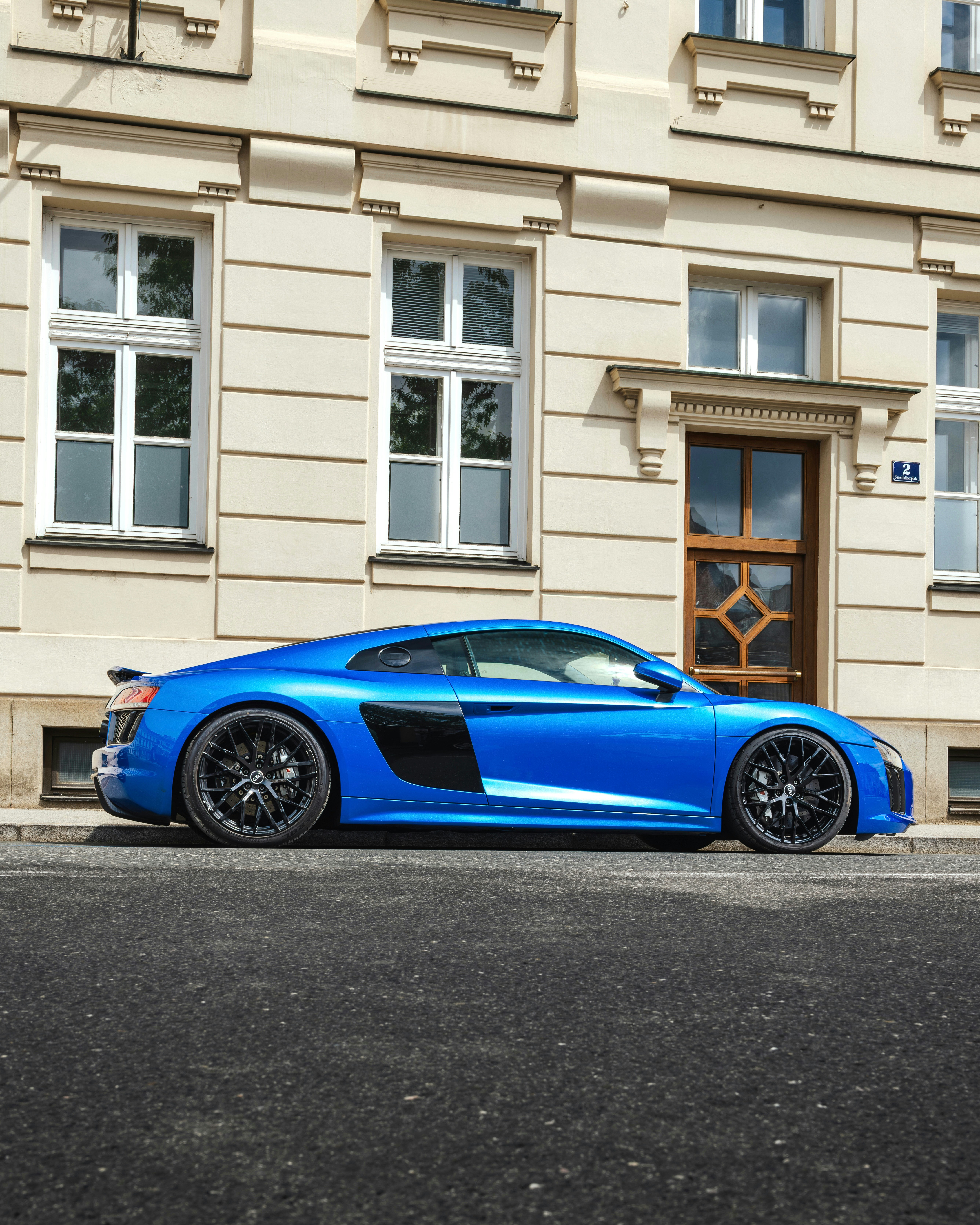 Blue Lightning: A Quad-Edge Audi R8 parked beside a beige façade
